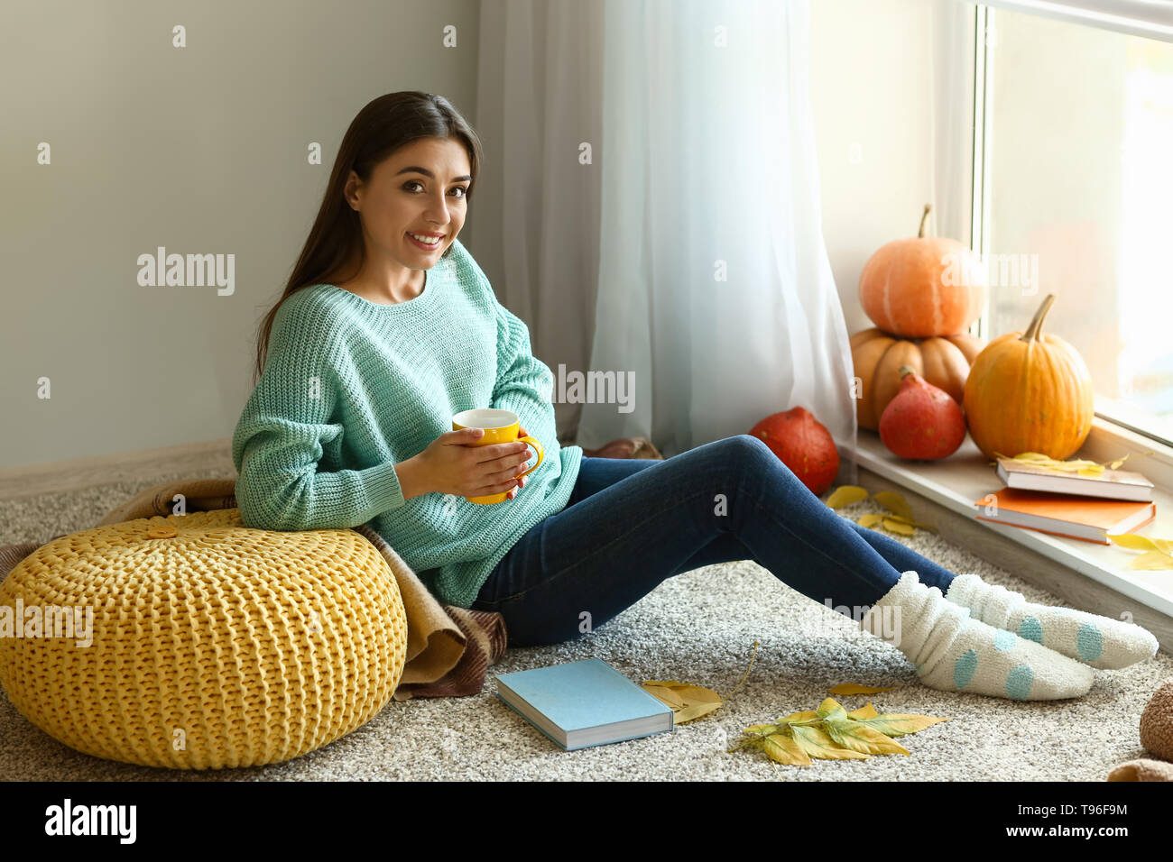 Woman drinking tea while resting at home on autumn day Stock Photo - Alamy