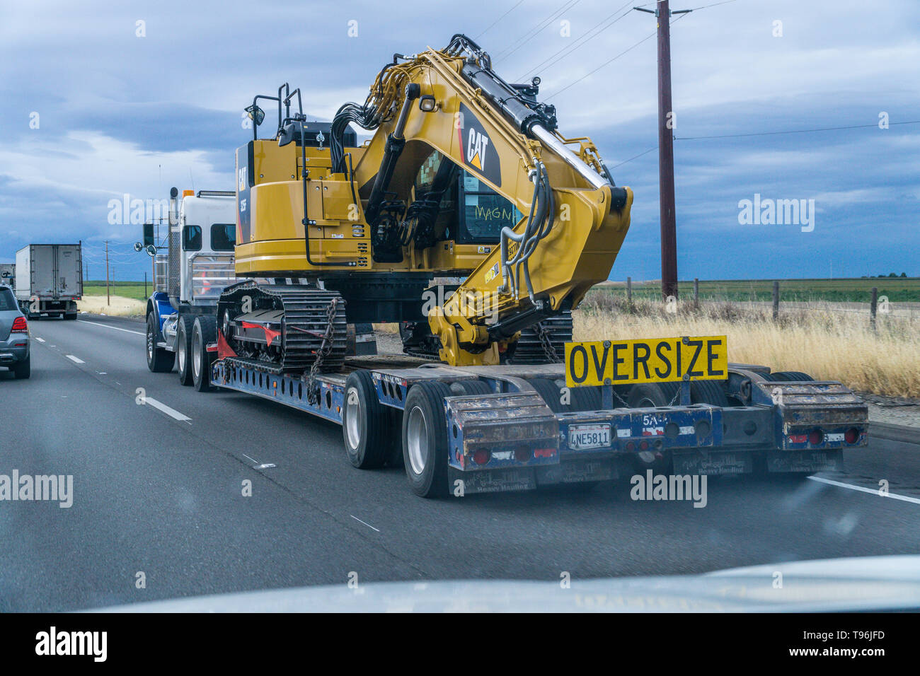 A new Caterpillar excavator on a low boy trailer traveling north on ...