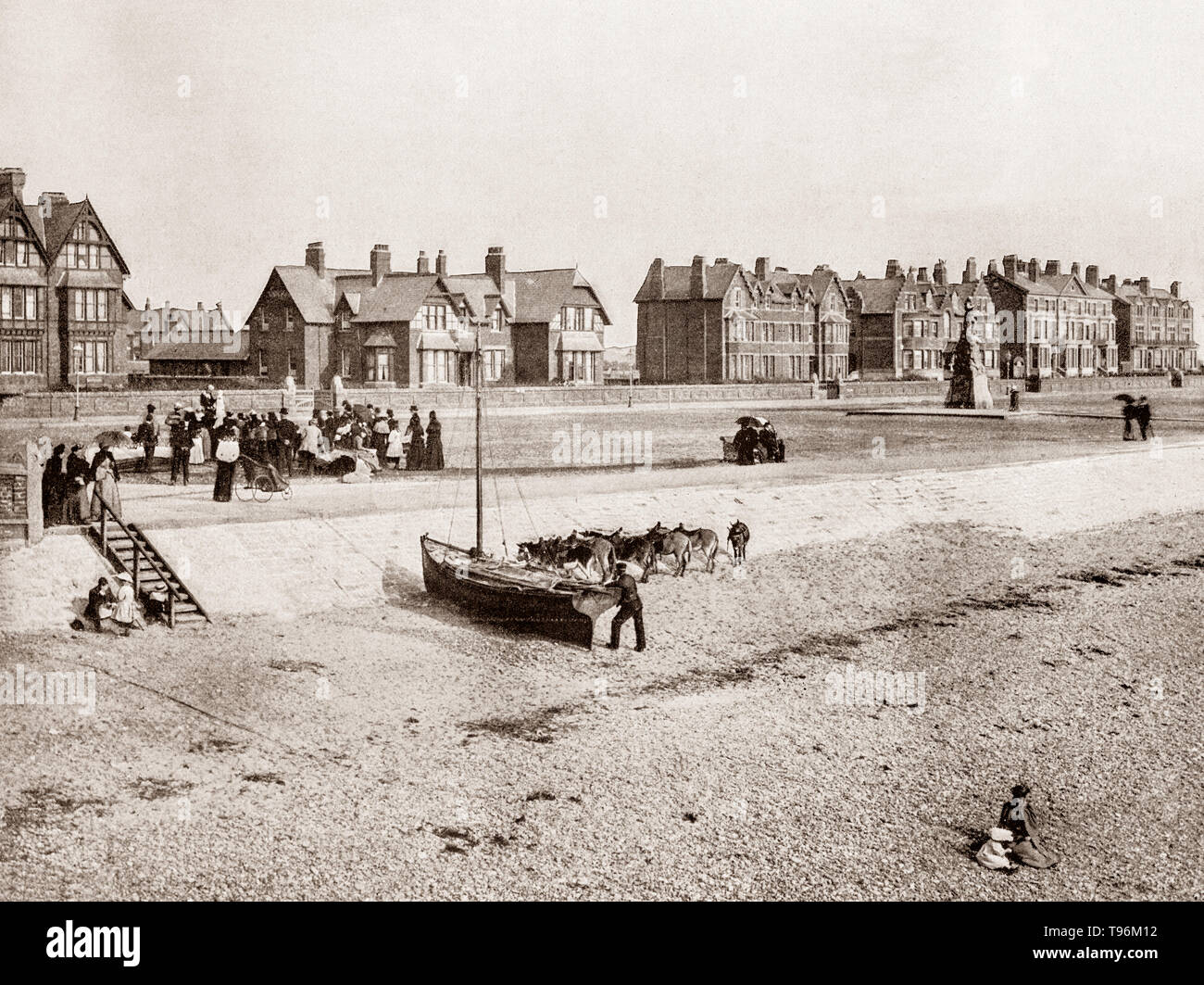 A late 19th Century view of a small sailing boat, donkeys and toursts ...