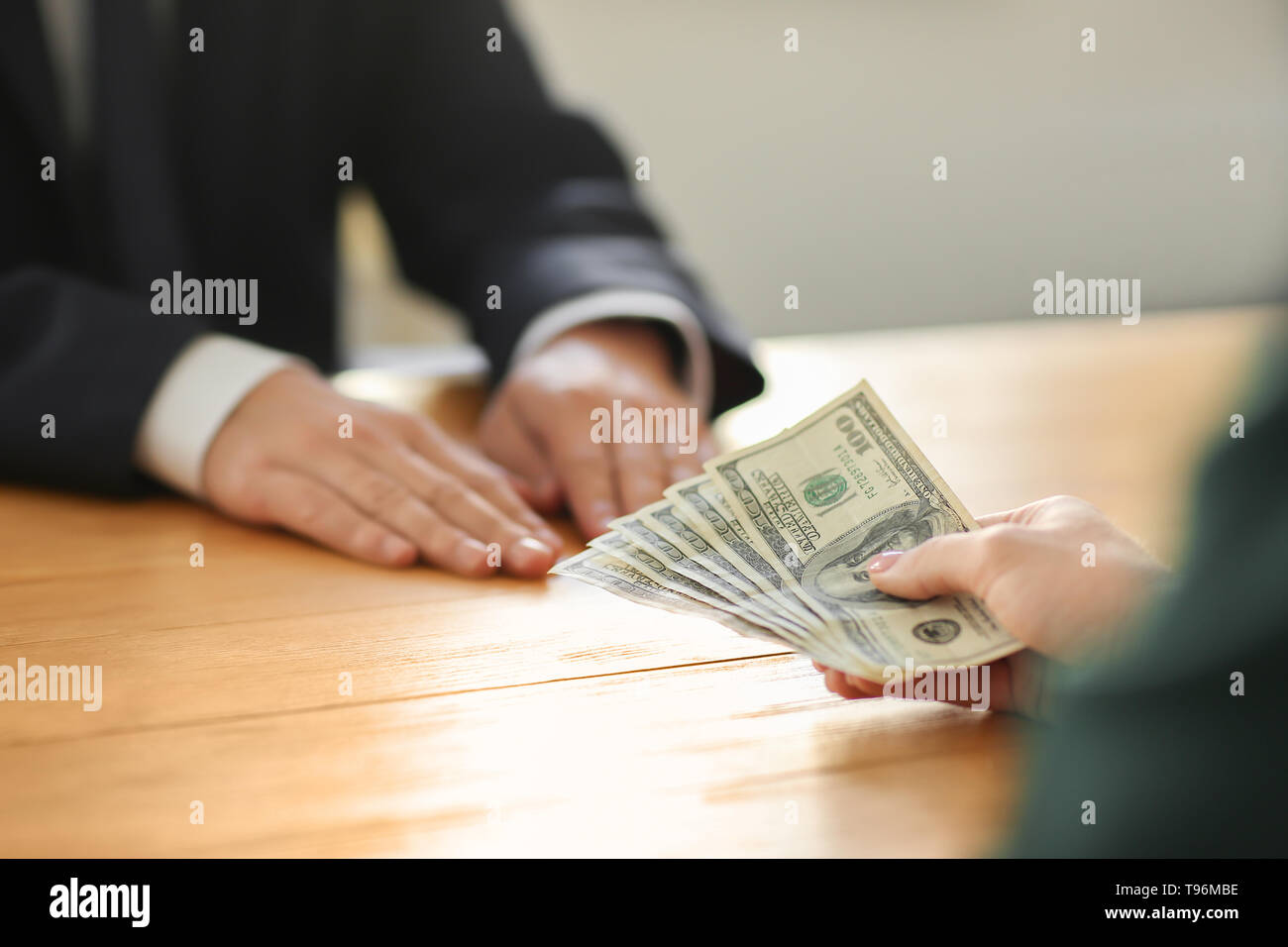 Woman giving bribe to businessman at table. Corruption concept Stock ...