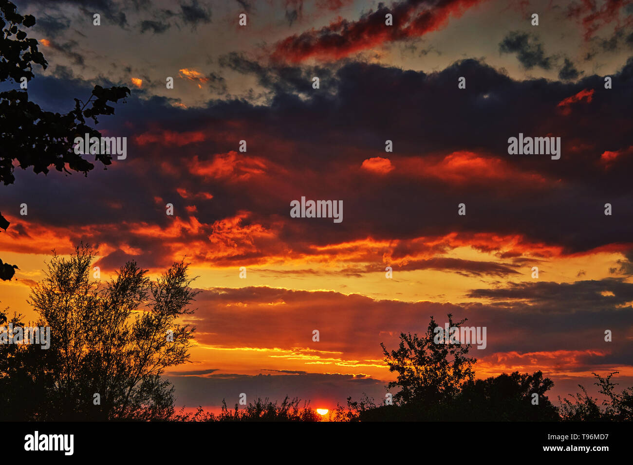 Orange sunset with dramatic clouds Stock Photo - Alamy