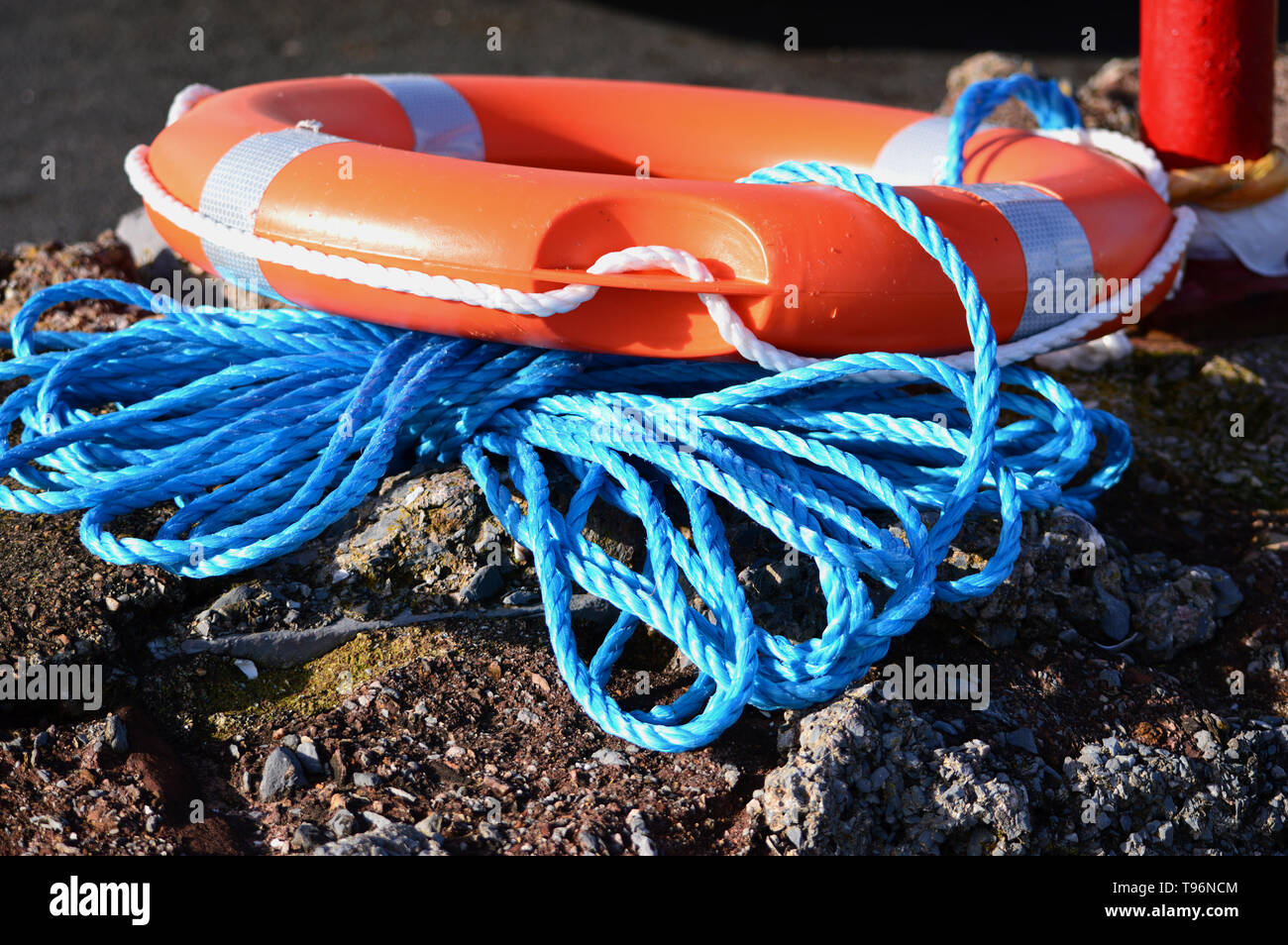 Red lifebelt with blue rope on beach promenade Stock Photo - Alamy