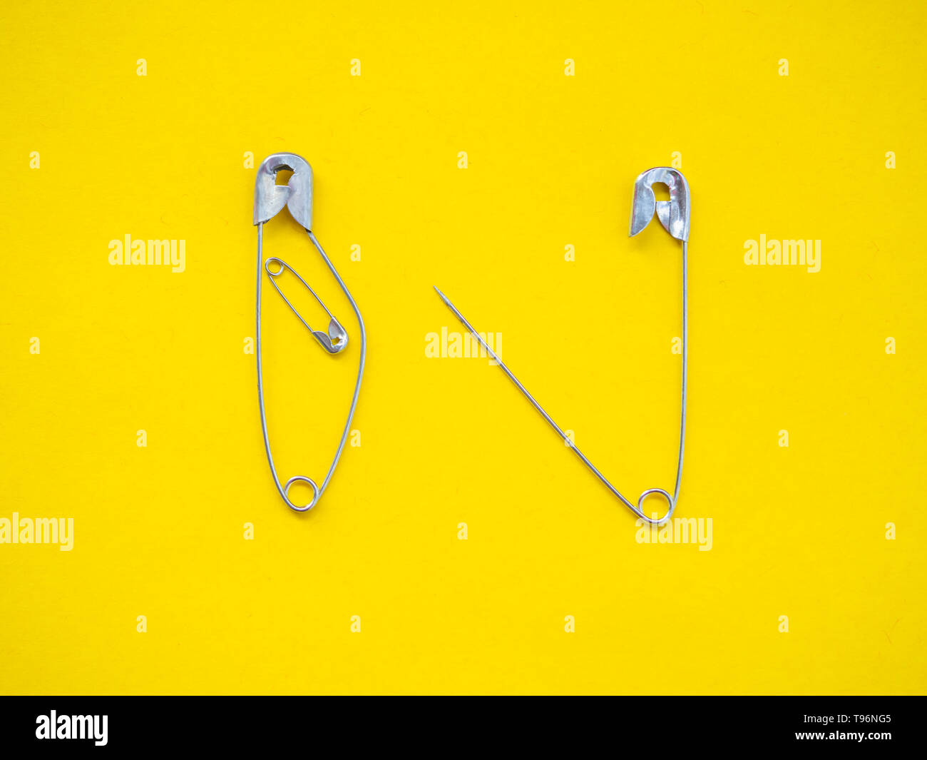 Several safety pins of various sizes in human representation. Concept ...