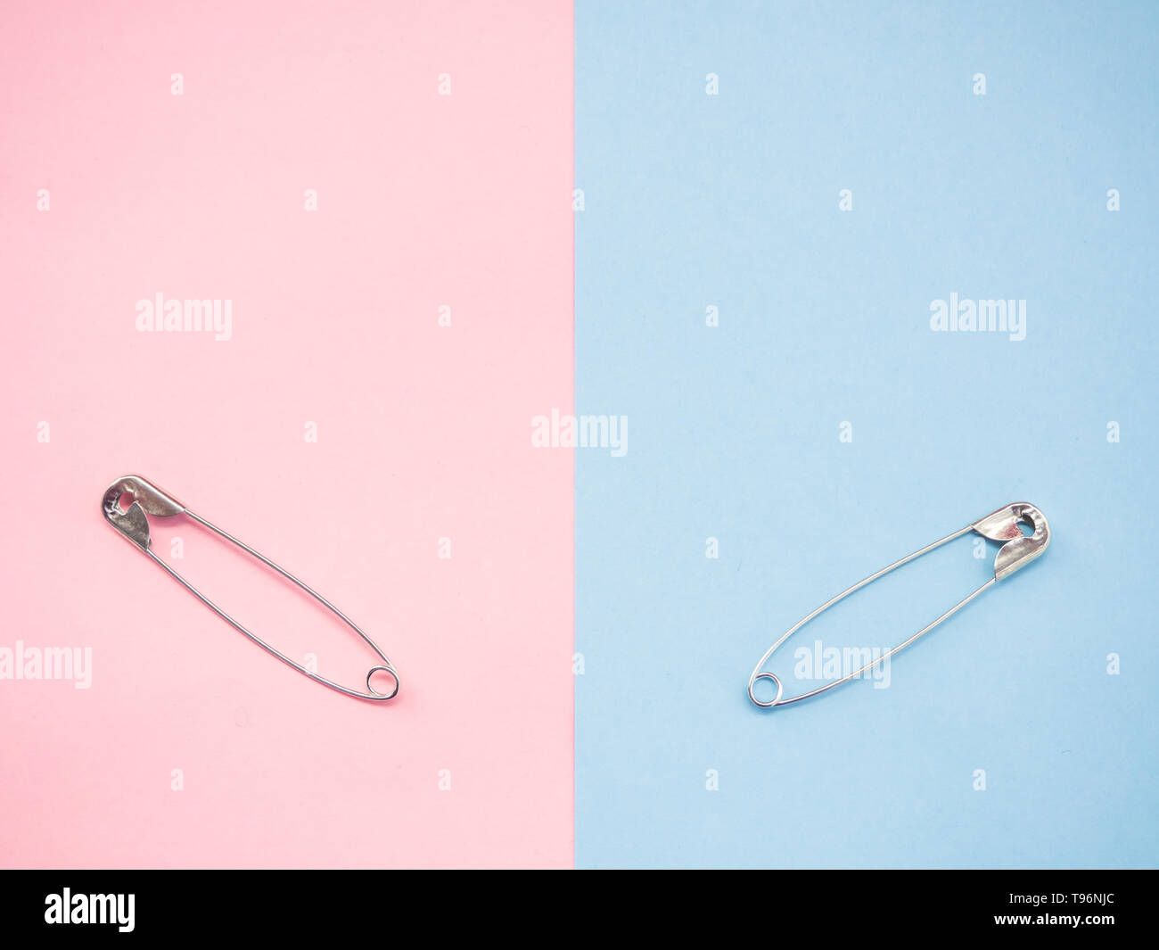Two safety pins representing a man and a woman. Concept of machismo and ...
