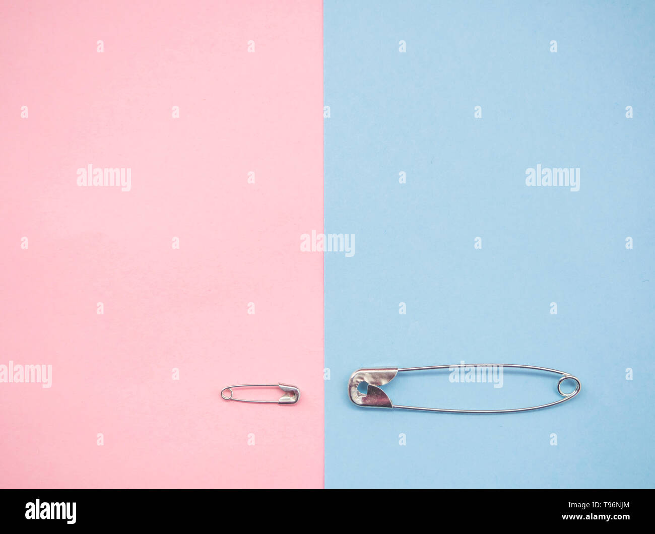 Two safety pins representing a man and a woman. Concept of machismo and ...