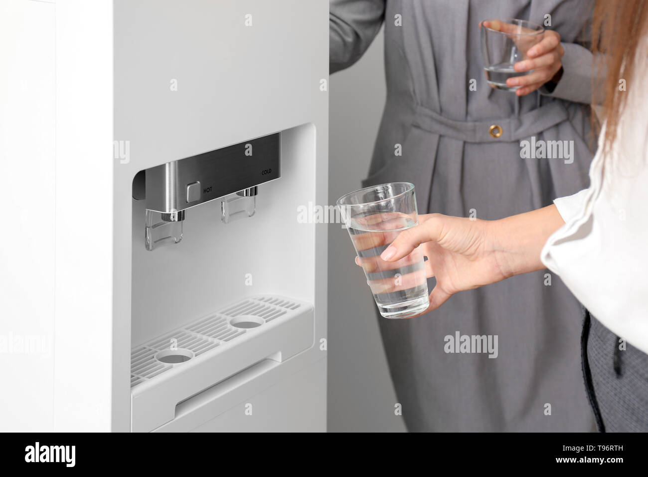 Women near water cooler hi-res stock photography and images - Alamy