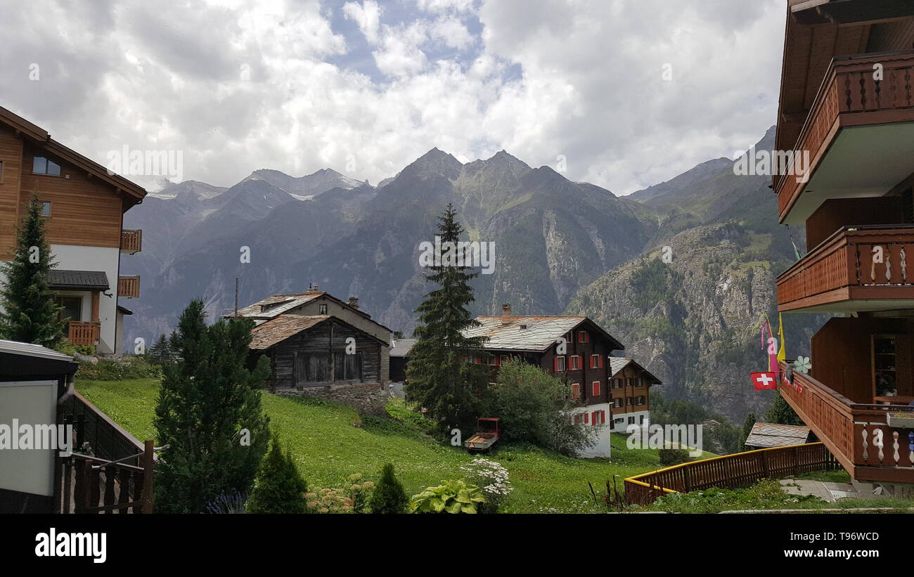 Typical Swiss village with wooden houses on top of the slope of the ...