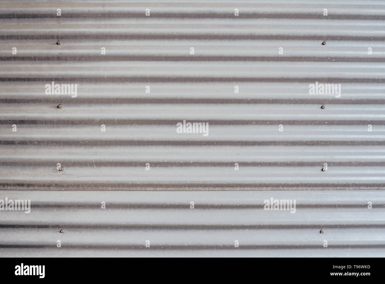 Wavy metal background on a gray wall Stock Photo - Alamy