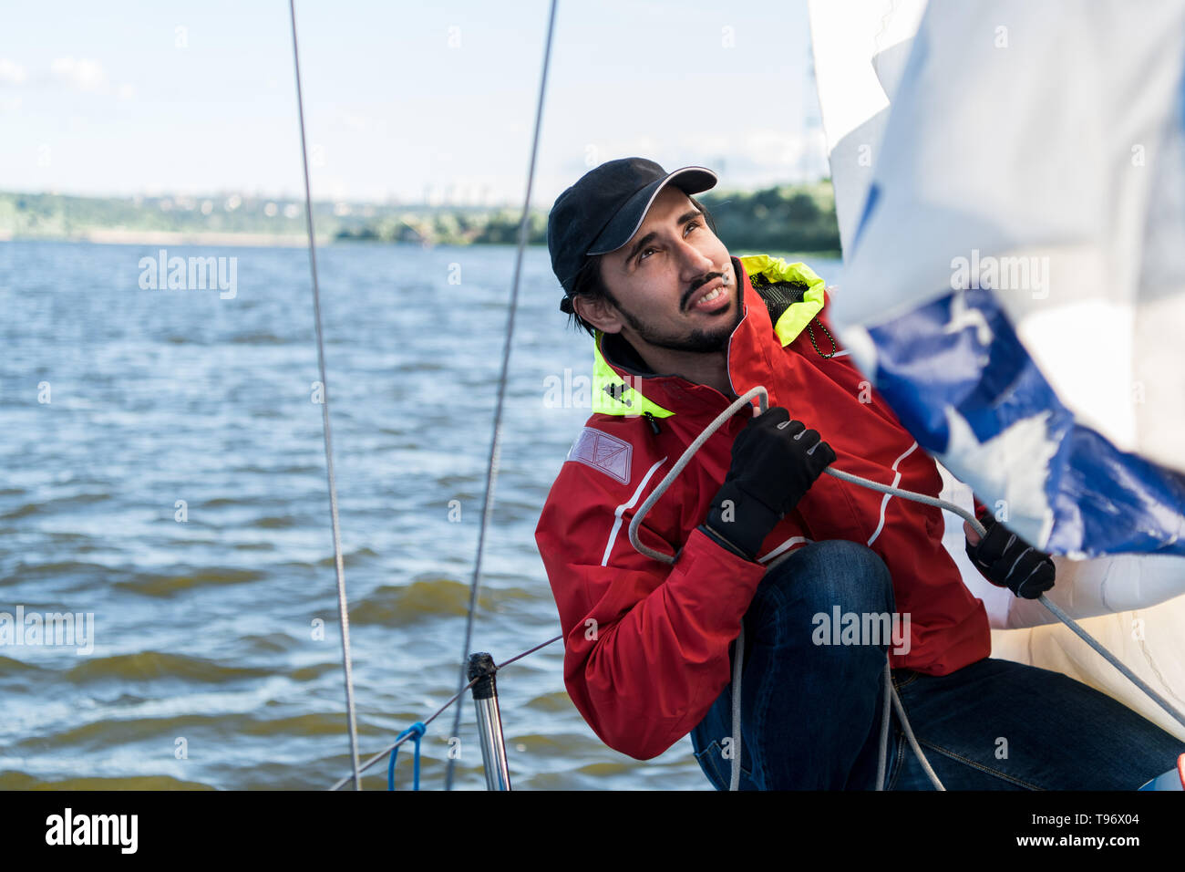 Yacht sailor pulling rope. Man working on sailboat Stock Photo - Alamy