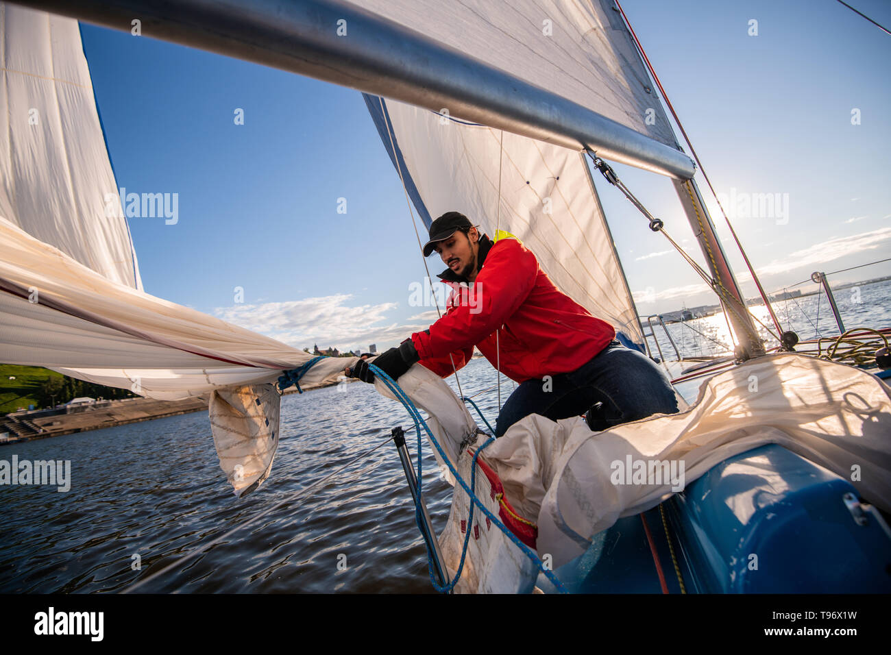 Yacht sailor pulling rope. Man working on sailboat Stock Photo - Alamy