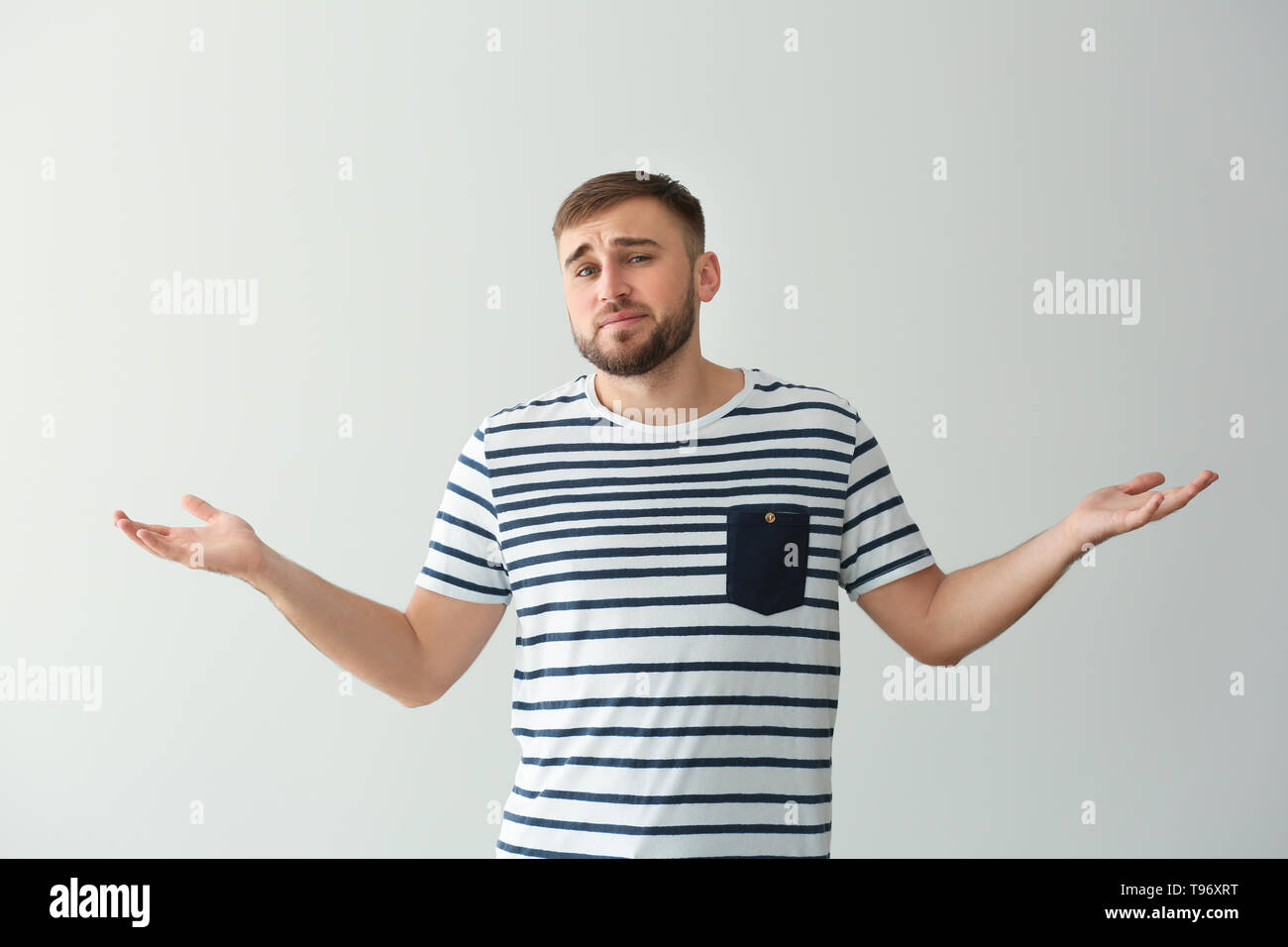 Emotional young man after making mistake on white background Stock ...