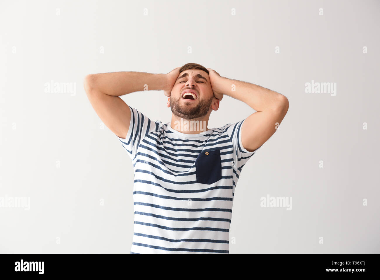 Emotional young man after making mistake on white background Stock ...