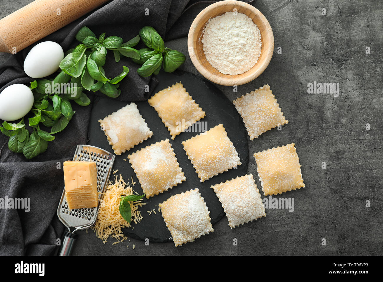 Uncooked ravioli with products on dark table Stock Photo - Alamy