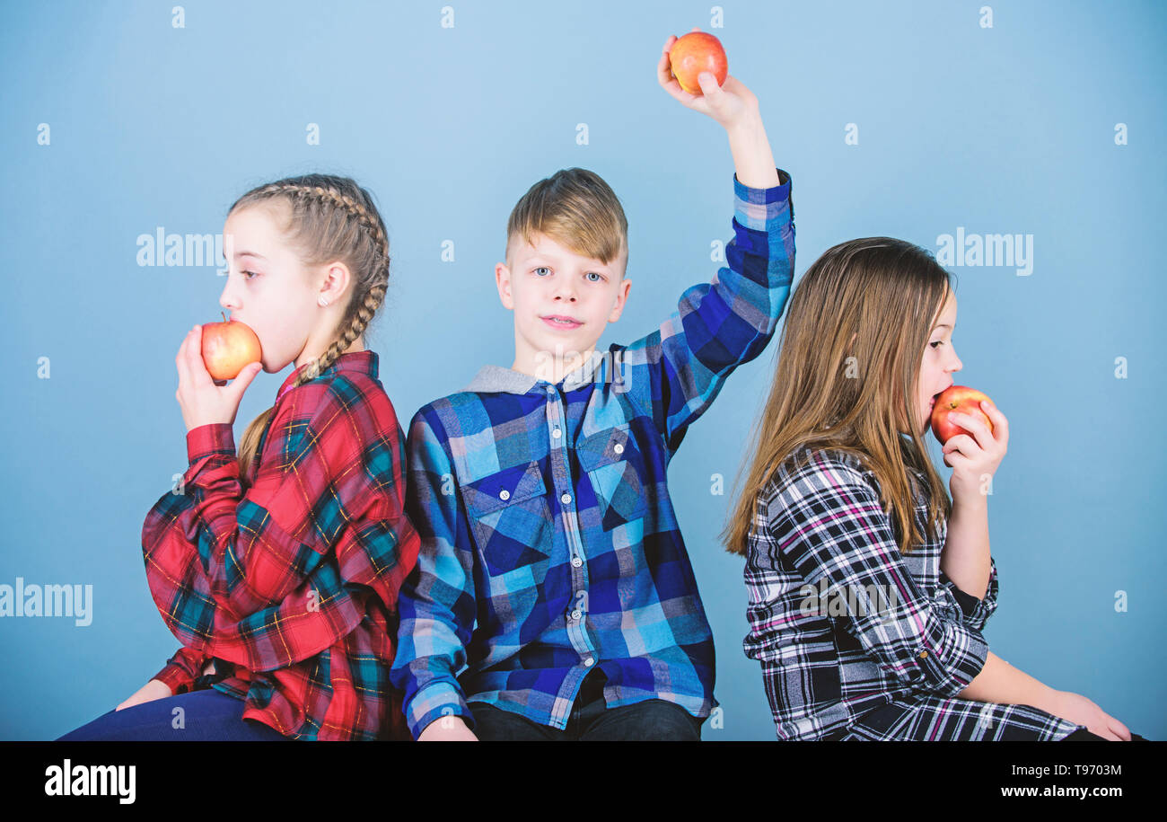 Healthy dieting and vitamin nutrition. Boy and girls friends eat apple ...