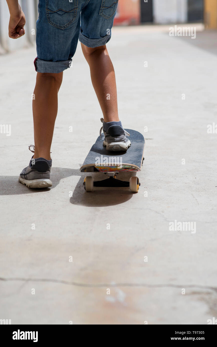 Rear view of a young skateboarder legs riding on skateboard Stock Photo ...