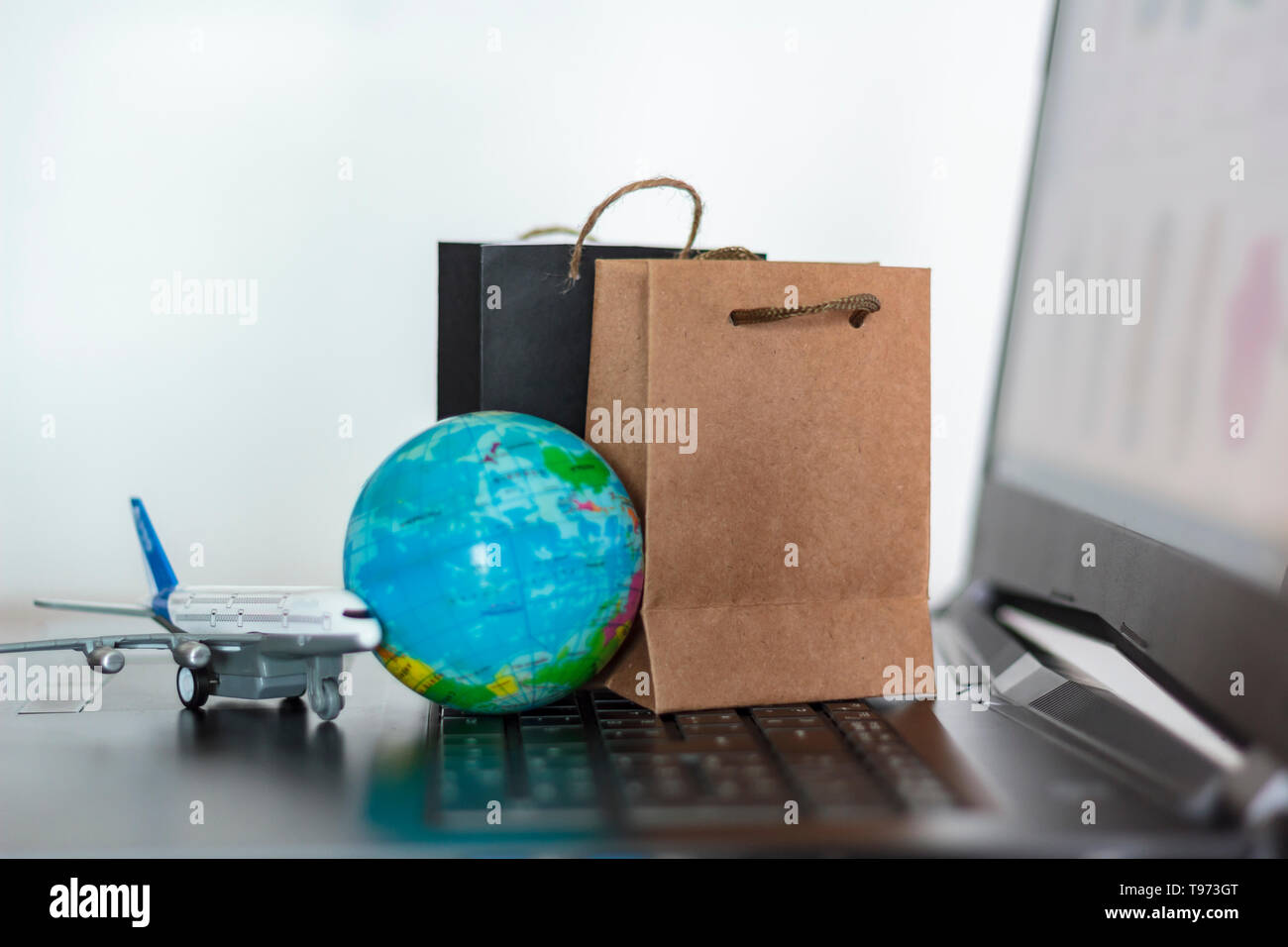 Shopping bags with world globe and airplane on laptop. Worldwide online ...
