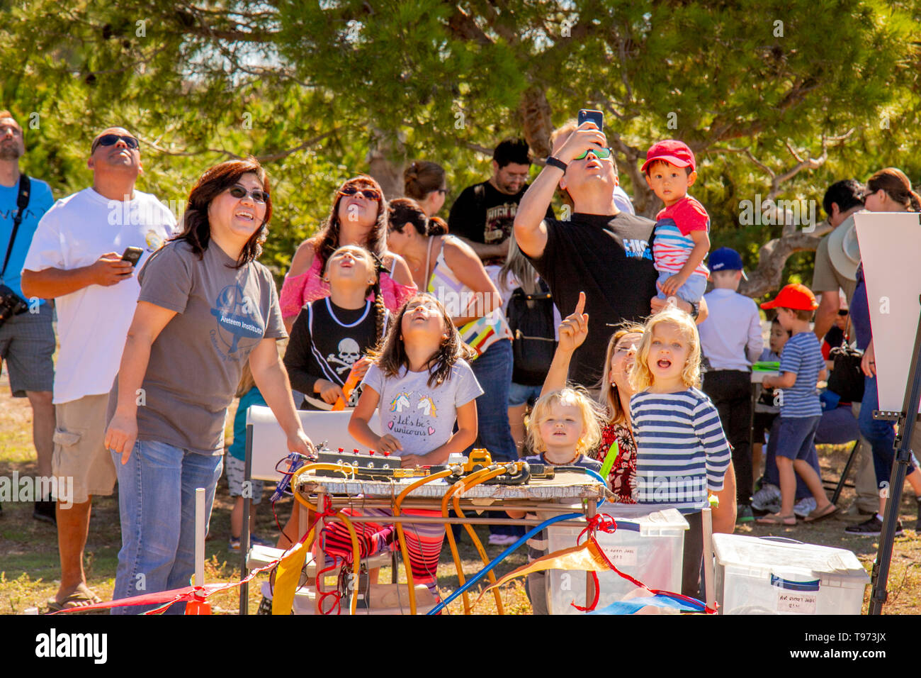 Families watch in amazement as paper air rockets powered by an air ...