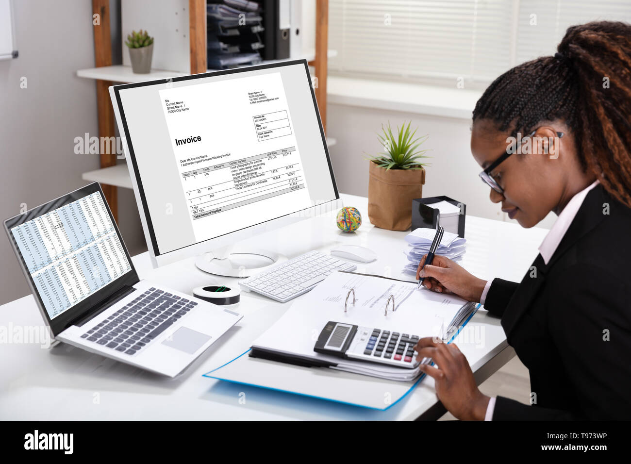 Side View Of Young Businesswoman Calculating Invoice On Computer Screen ...