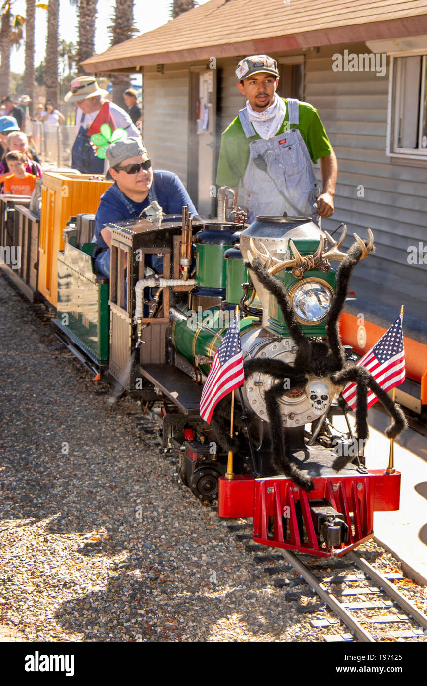 Decorated with antlers and the US flag, a miniature steam locomotive ...