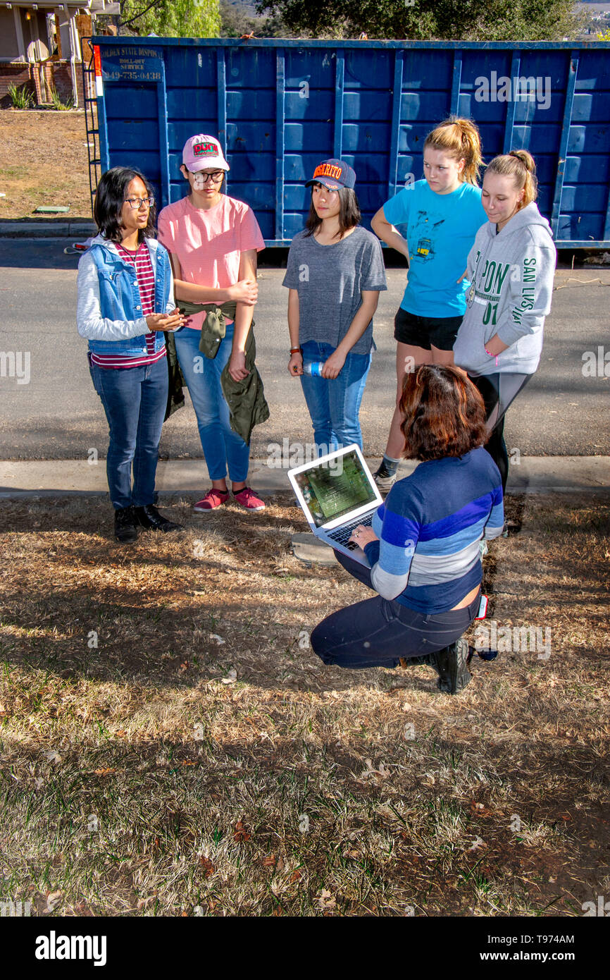 Using a laptop as a notebook, a female newspaper reporter interviews a ...