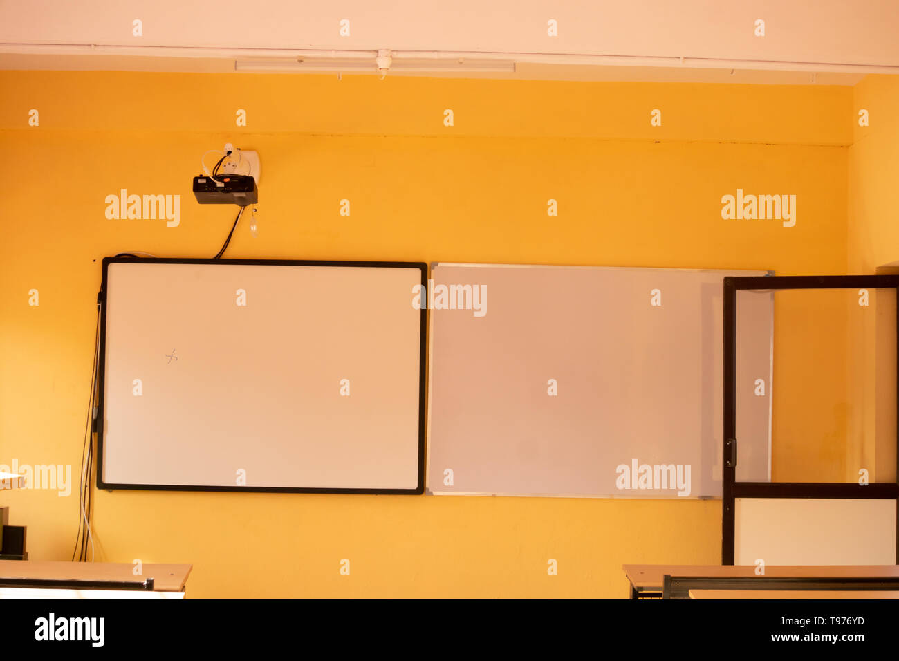 Classroom with yellow walls and white boards with projector Stock Photo ...