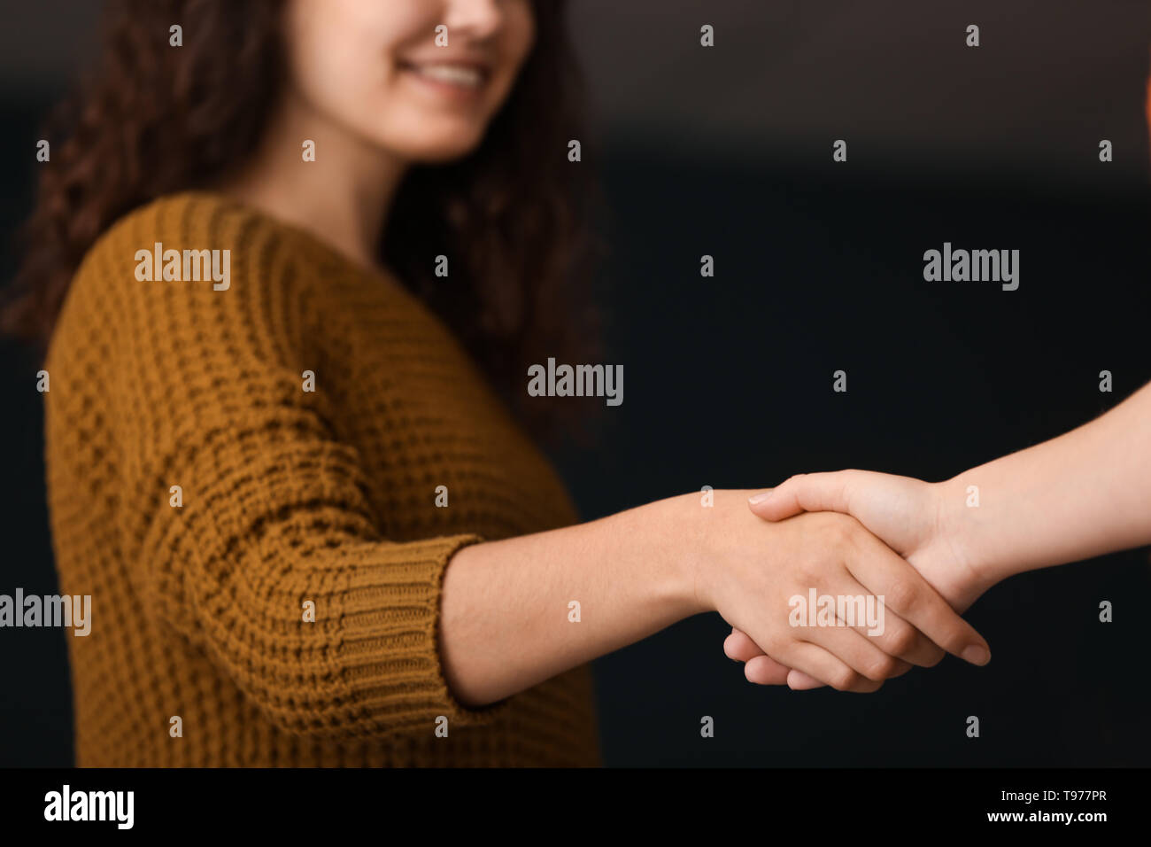 People shaking hands on dark background Stock Photo - Alamy