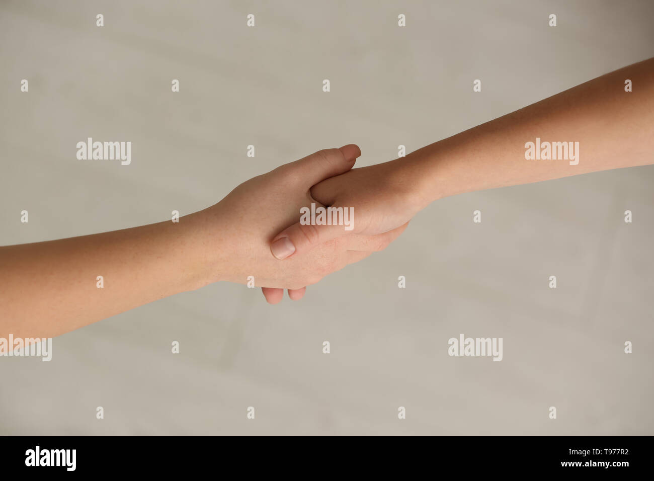 People shaking hands on light background Stock Photo - Alamy
