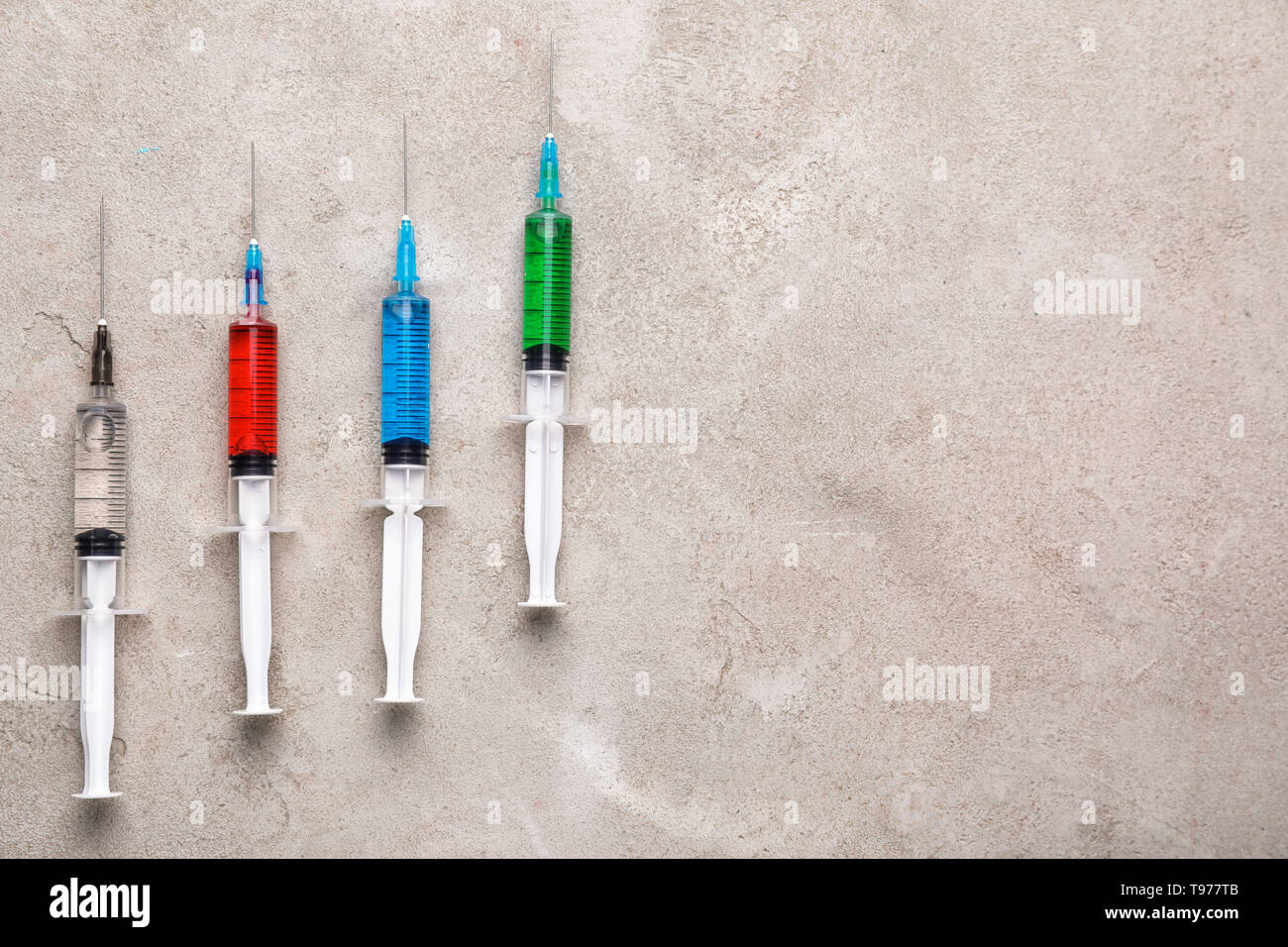 Syringes with liquids on grey background Stock Photo - Alamy