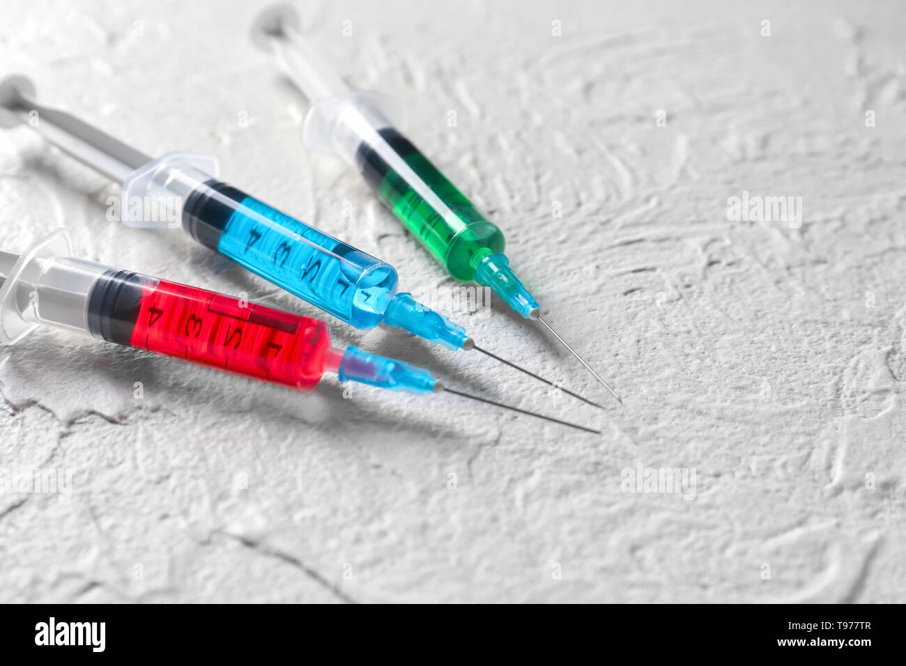 Syringes with liquids on white textured background Stock Photo - Alamy