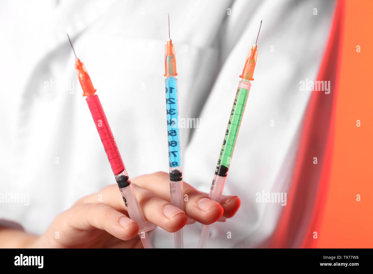 Doctor holding syringes full of liquids, closeup Stock Photo - Alamy