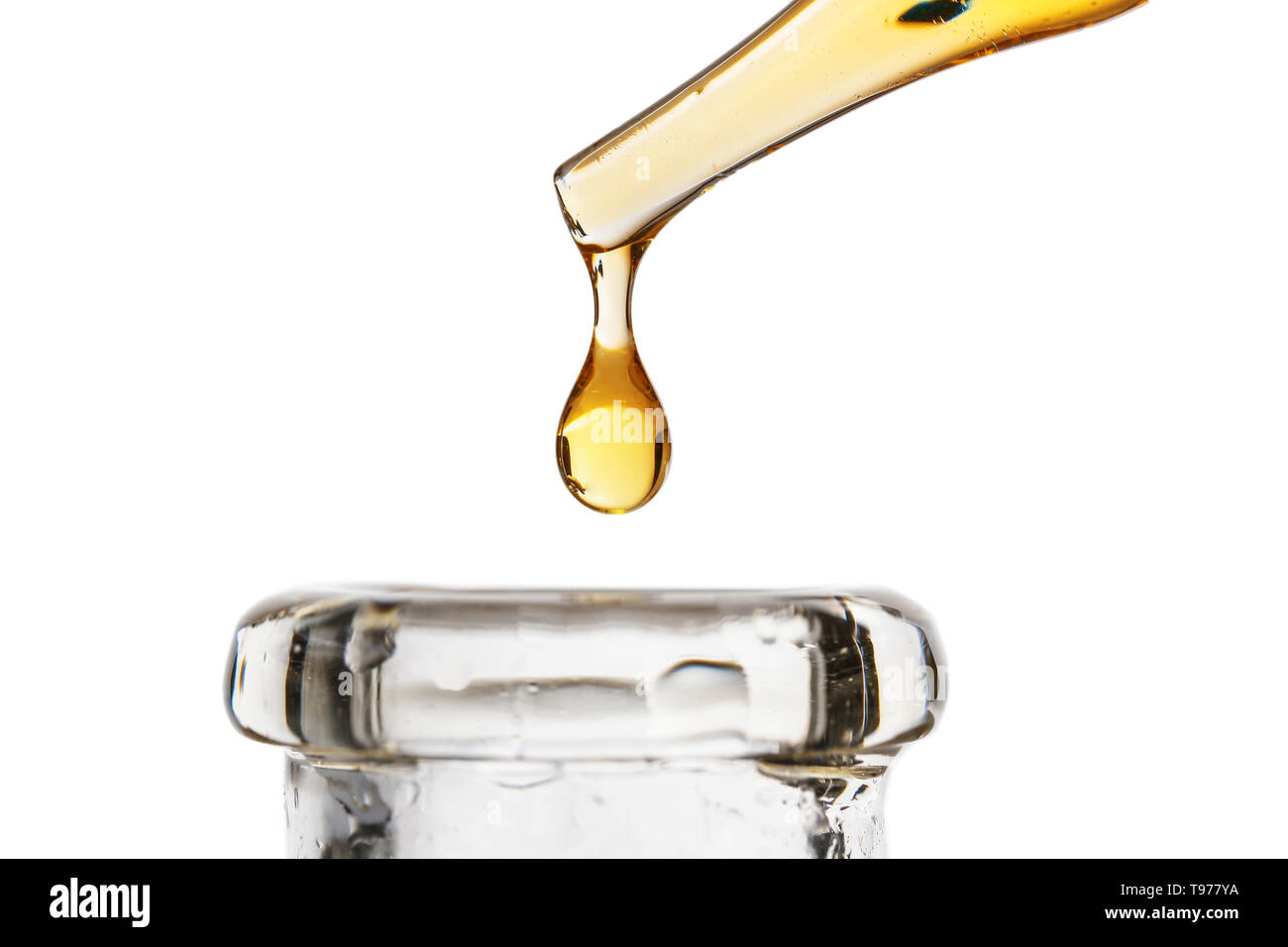Dripping oil from pipette into glass bottle on white background Stock ...