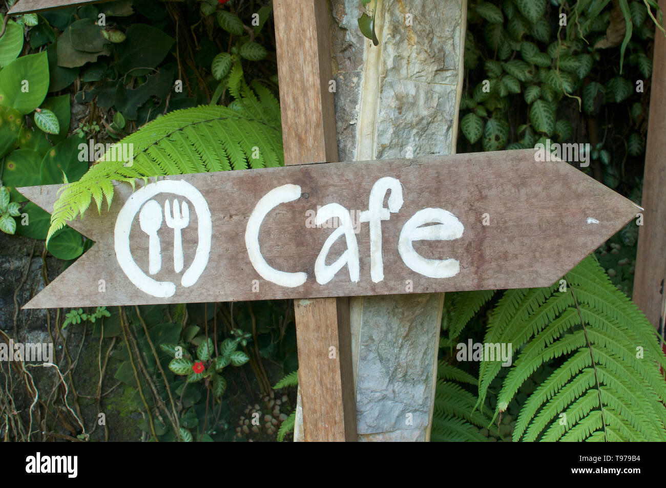White Cafe writing on a wooden arrow shaped plank, located outside a ...