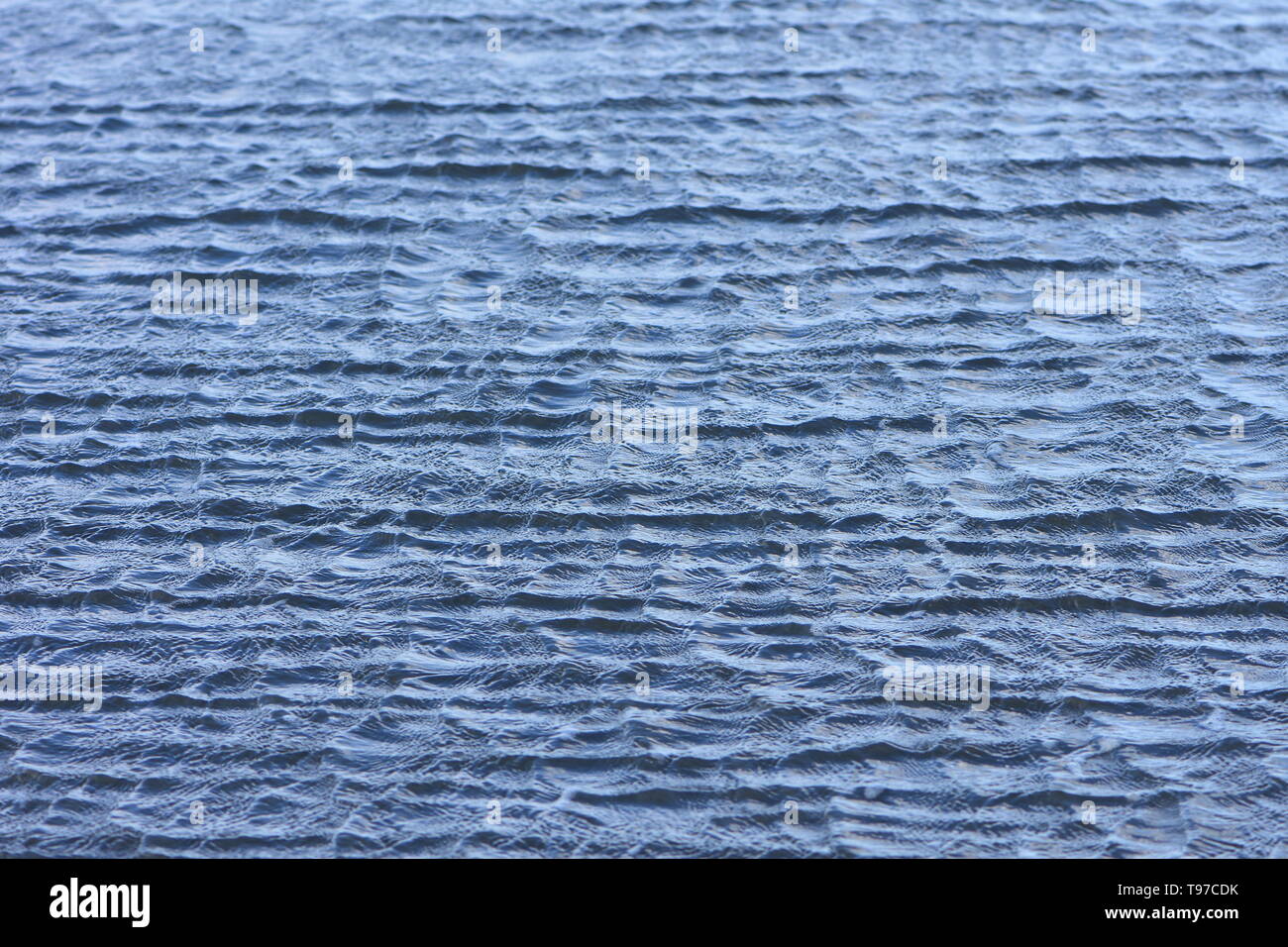 Pattern of steel blue sea surface with tiny choppy irregular waves ...