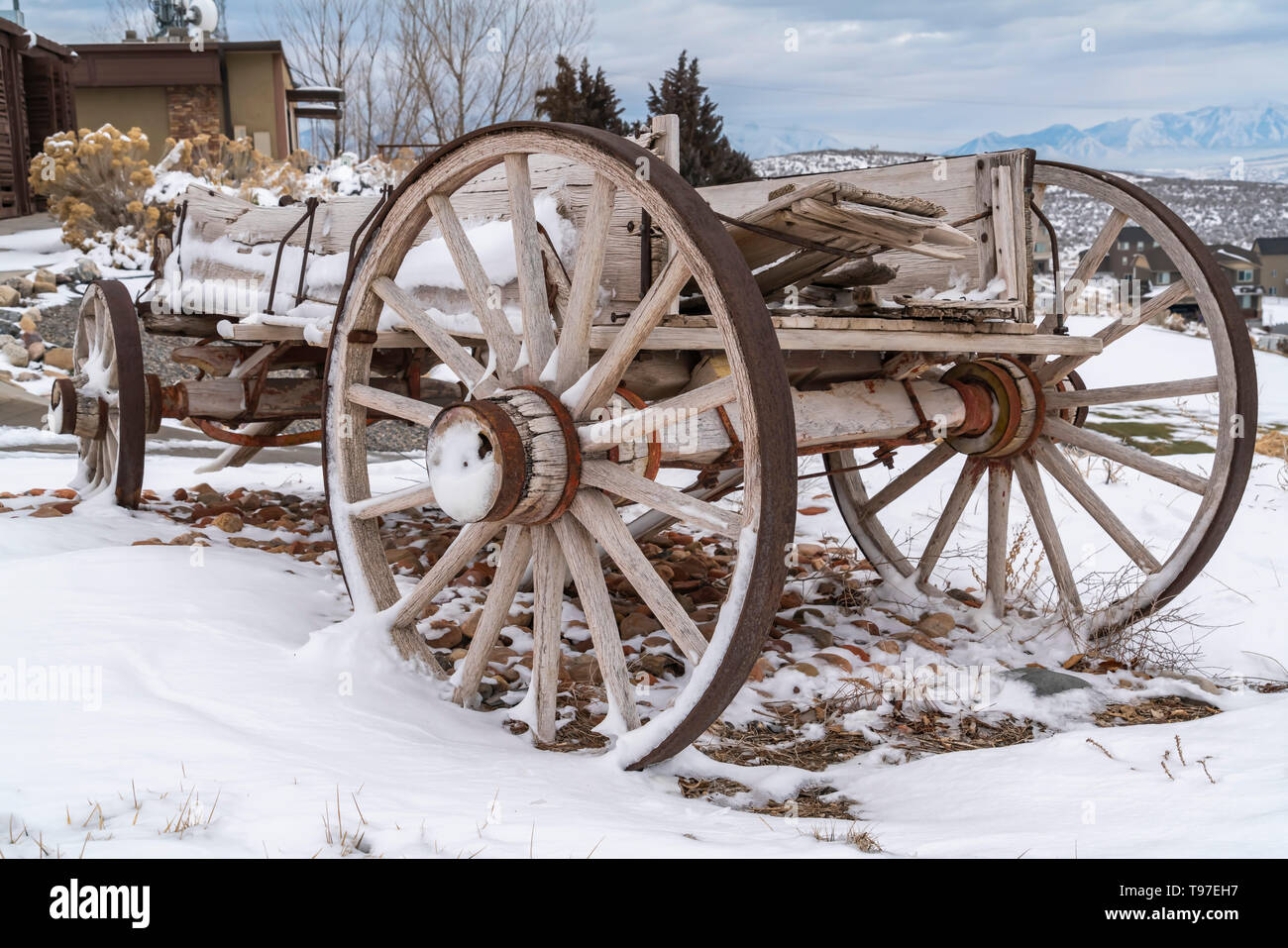 Weathered wagon against a scenic landscape blanketed with snow in ...