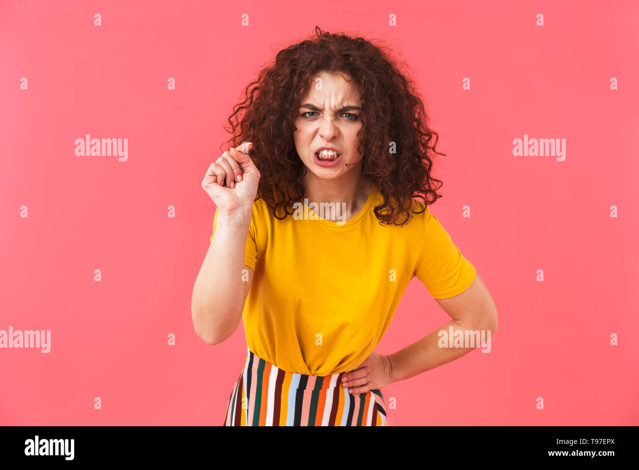 Image of a displeased angry beautiful young curly girl posing isolated ...