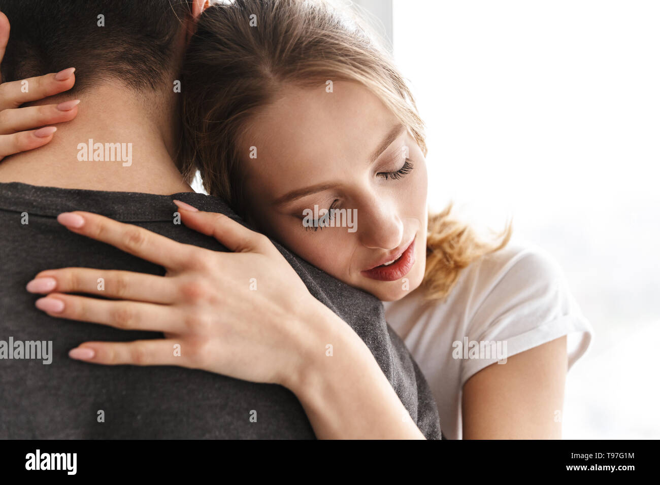 Portrait of lovely couple smiling and hugging together while standing ...