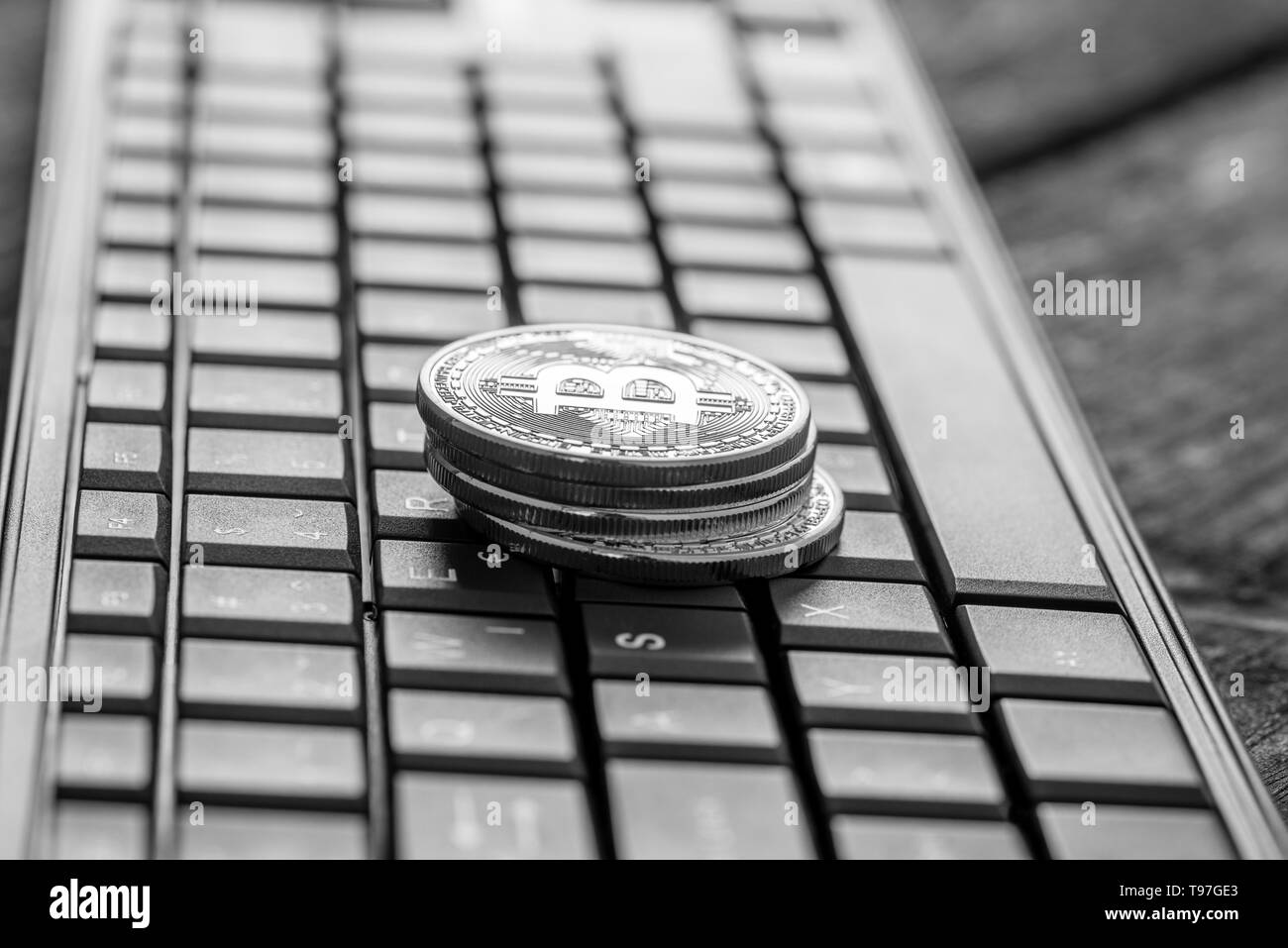 Pile of metal coins with Bitcoin sign over black computer keyboard in ...
