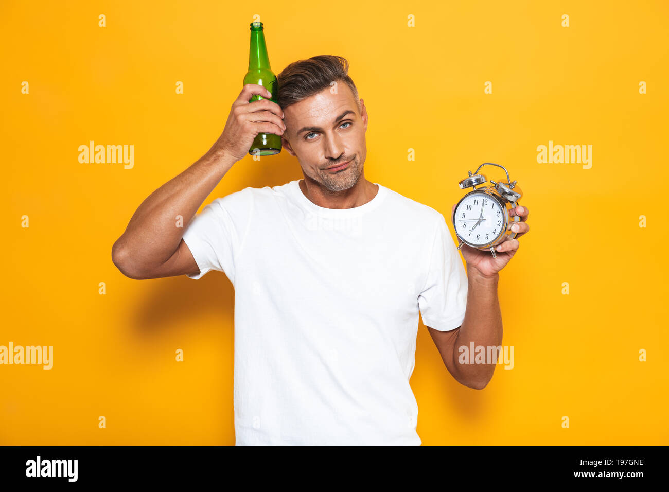 Image of brunette man 30s in white t-shirt drinking beer and holding ...