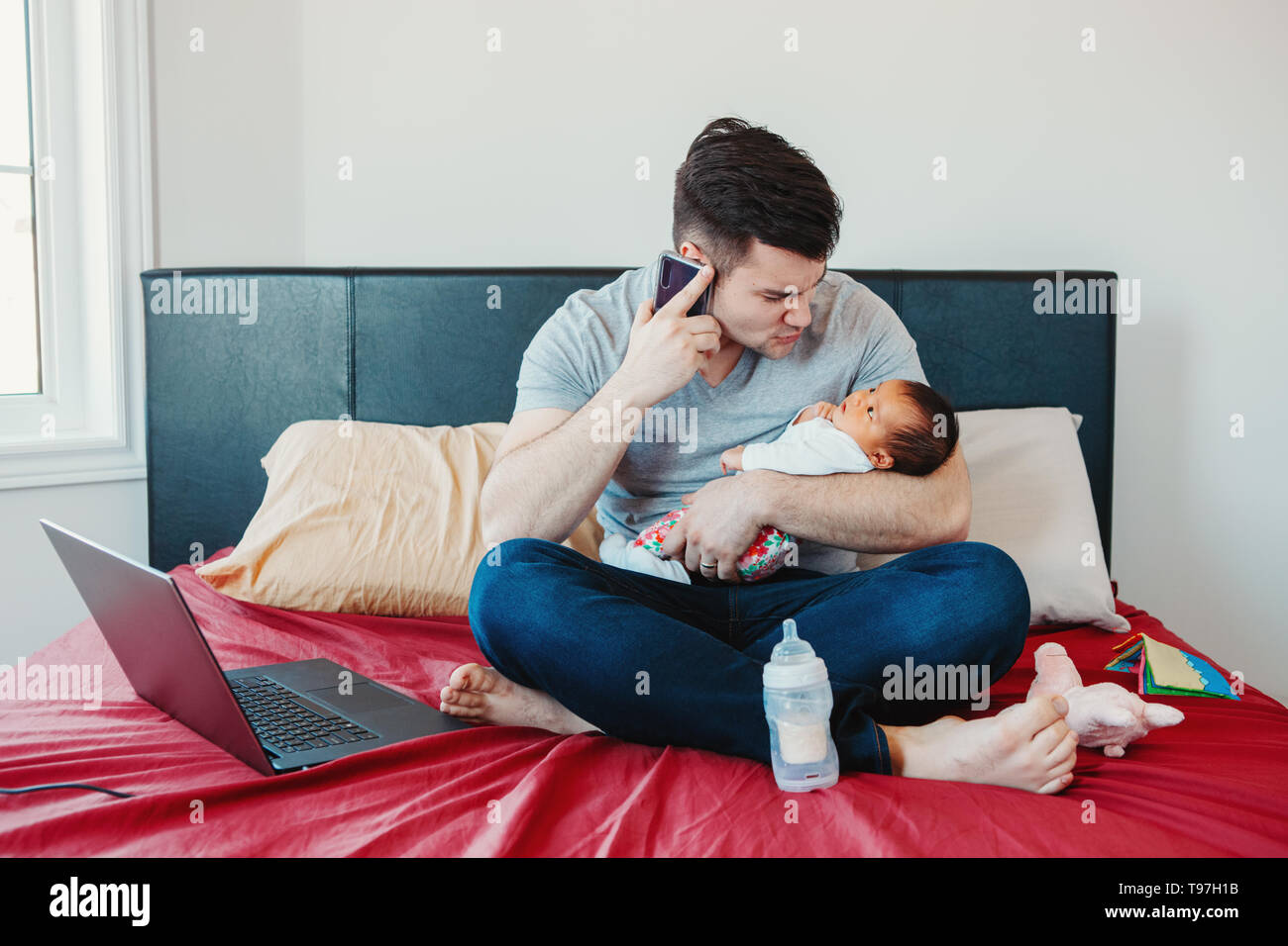 Caucasian father dad with newborn mixed race Asian Chinese baby working ...