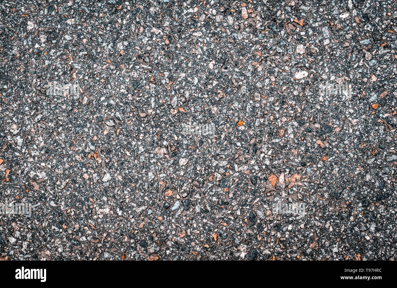 The texture of light smooth asphalt with small colored stones ...