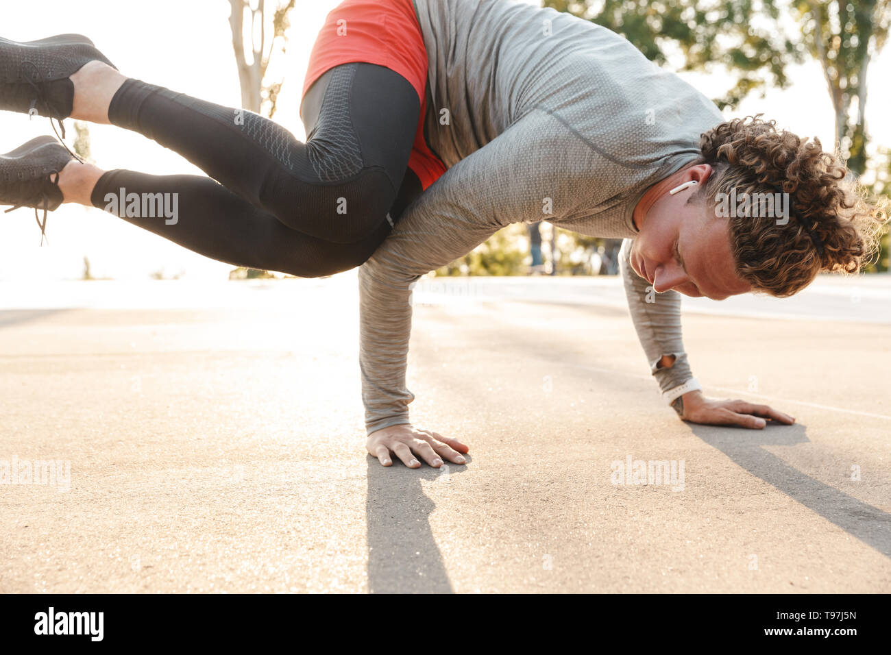 Healthy young sportsman doing exercises outdoors Stock Photo - Alamy