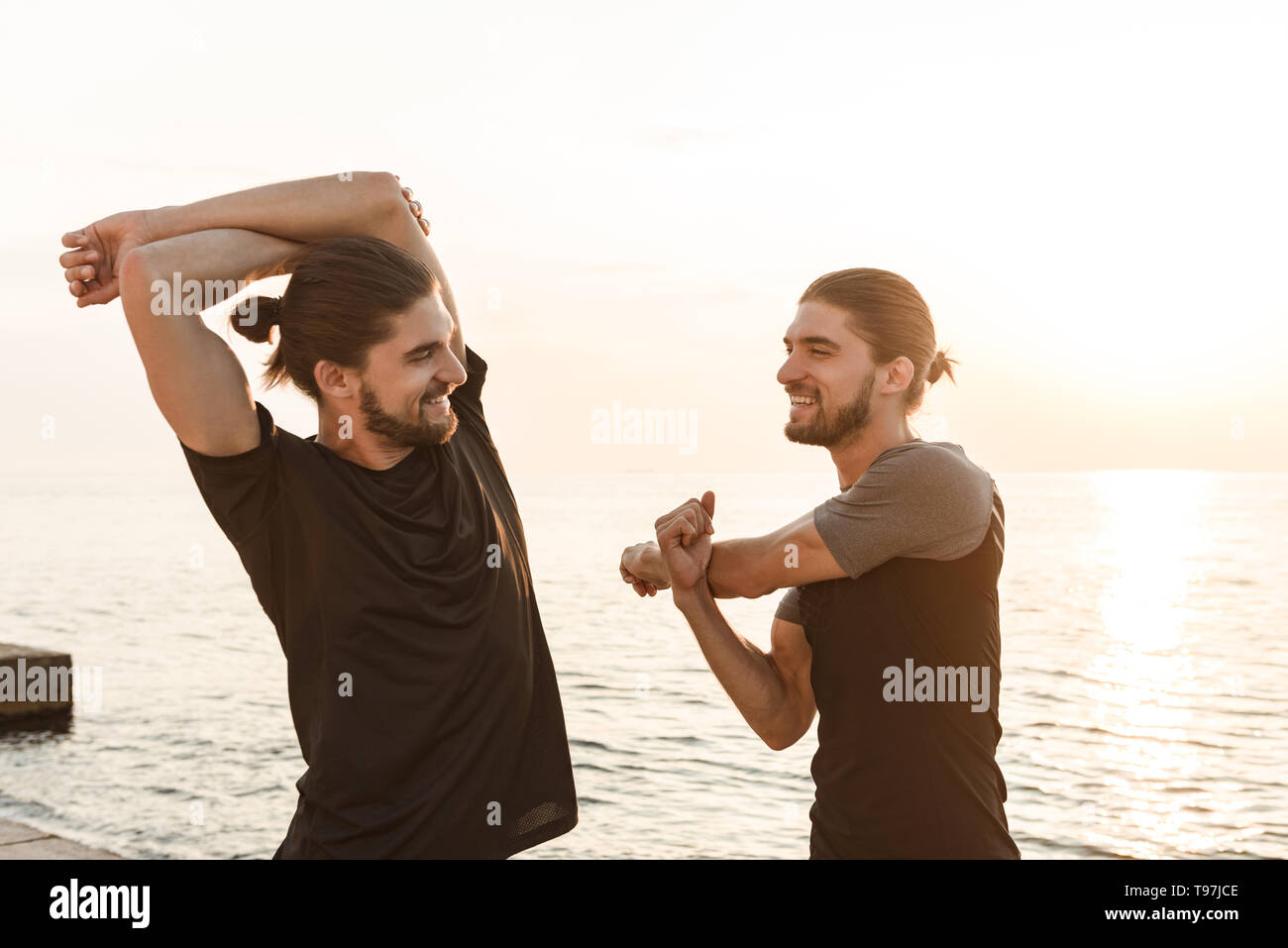 Two twin brothers doing exercises at the beach together Stock Photo - Alamy