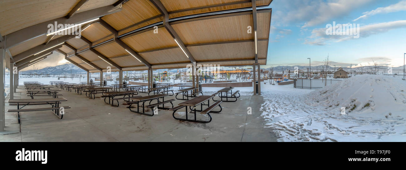 Covered picnic area and playground at a park blanketed with snow in ...