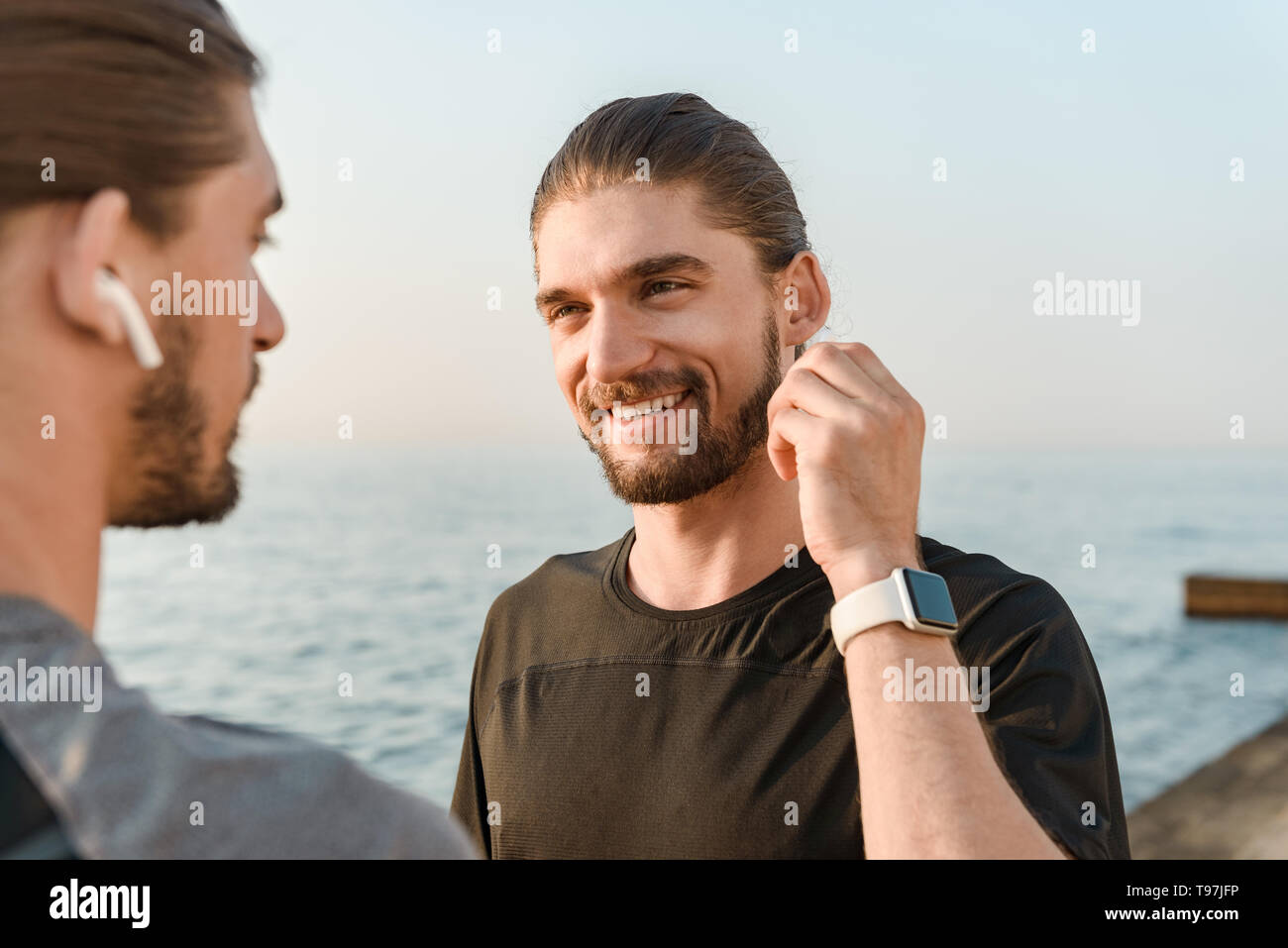 Two twin brothers doing exercises at the beach together, talking Stock ...