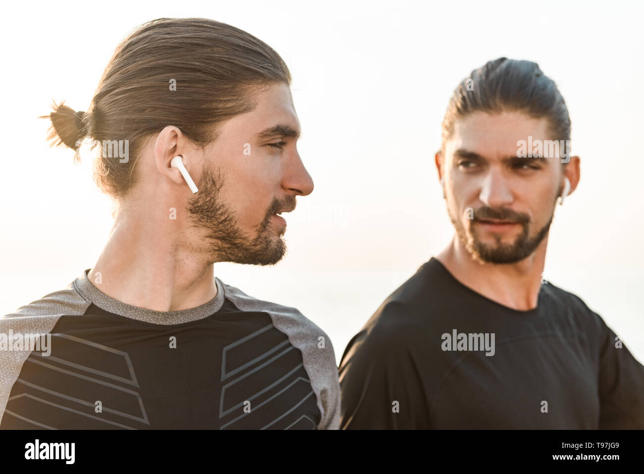 Close up of a two twin brothers doing exercises at the beach together ...
