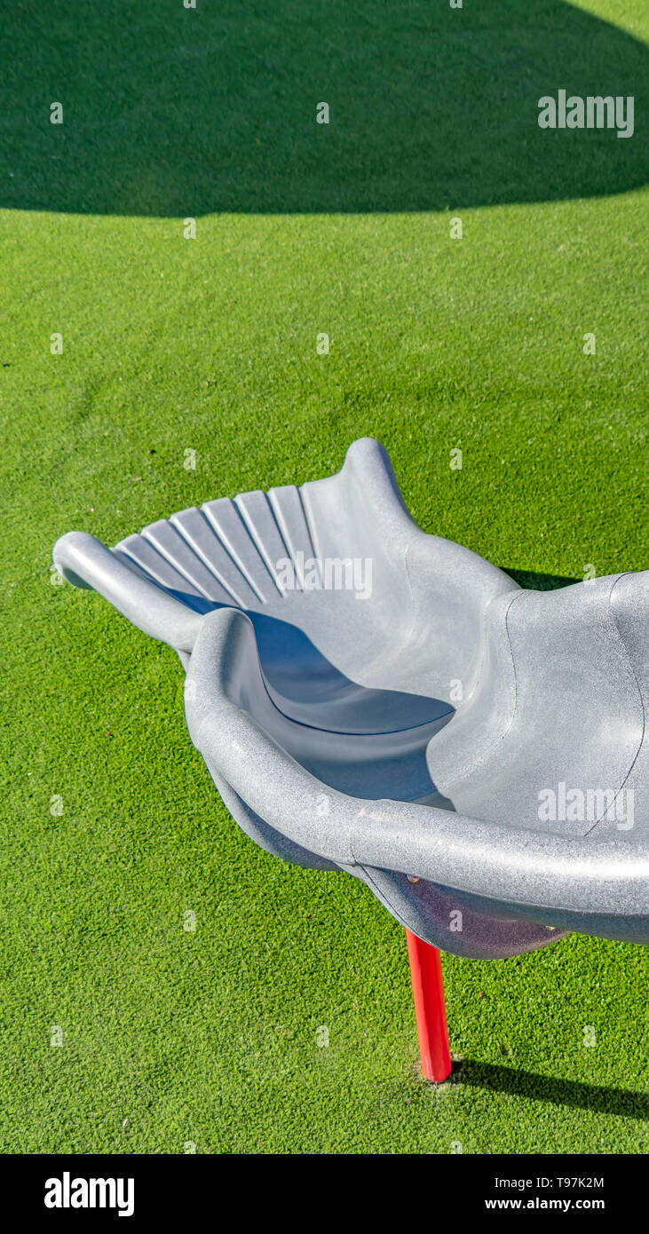 Vertical Shiny gray slide of a playground viewed against a vibrant ...