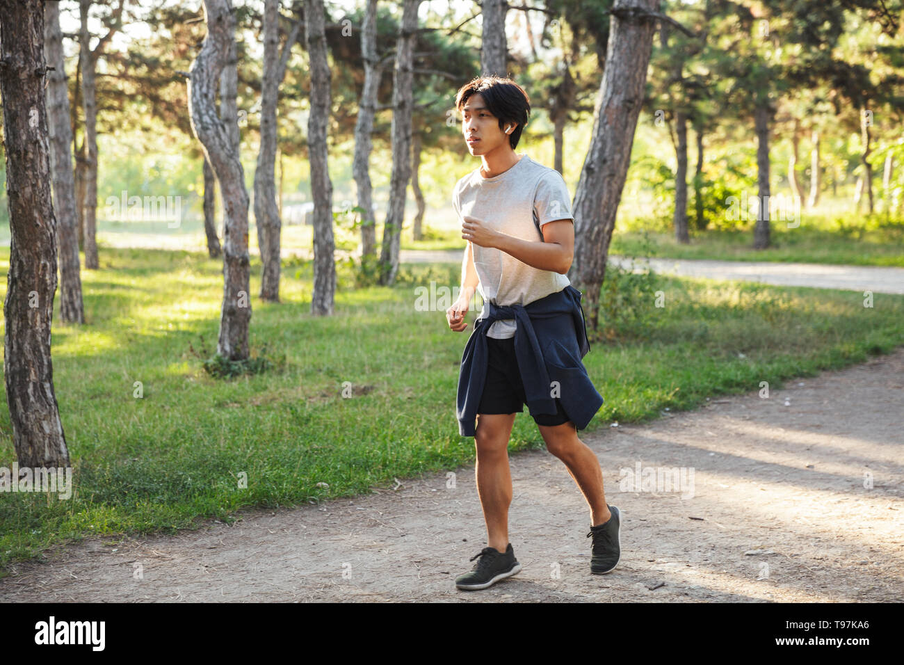 Full length of a confident asian athlete man running at the park Stock ...