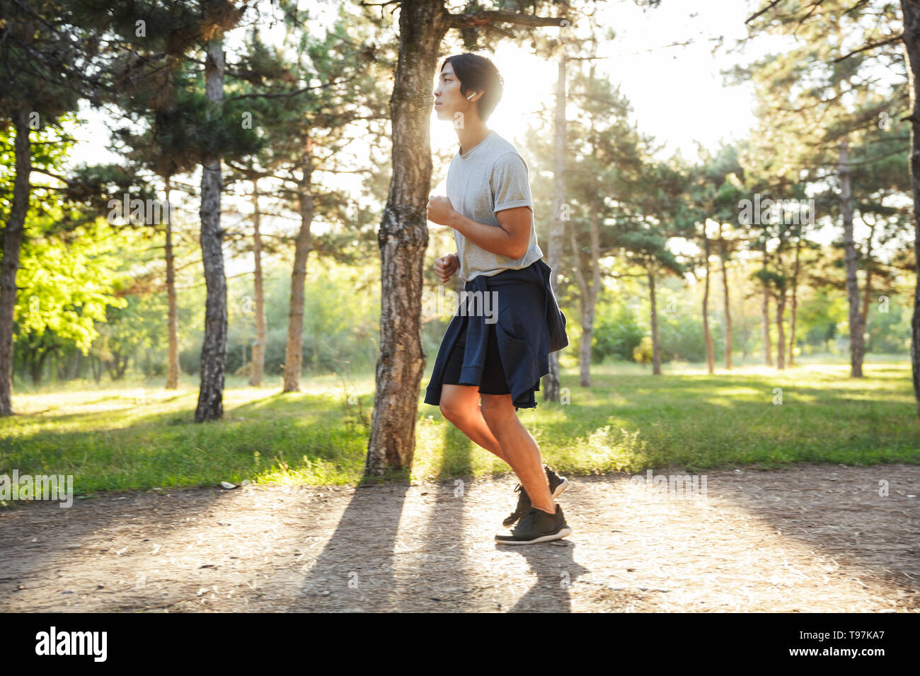 Full length of a confident asian athlete man running at the park Stock ...
