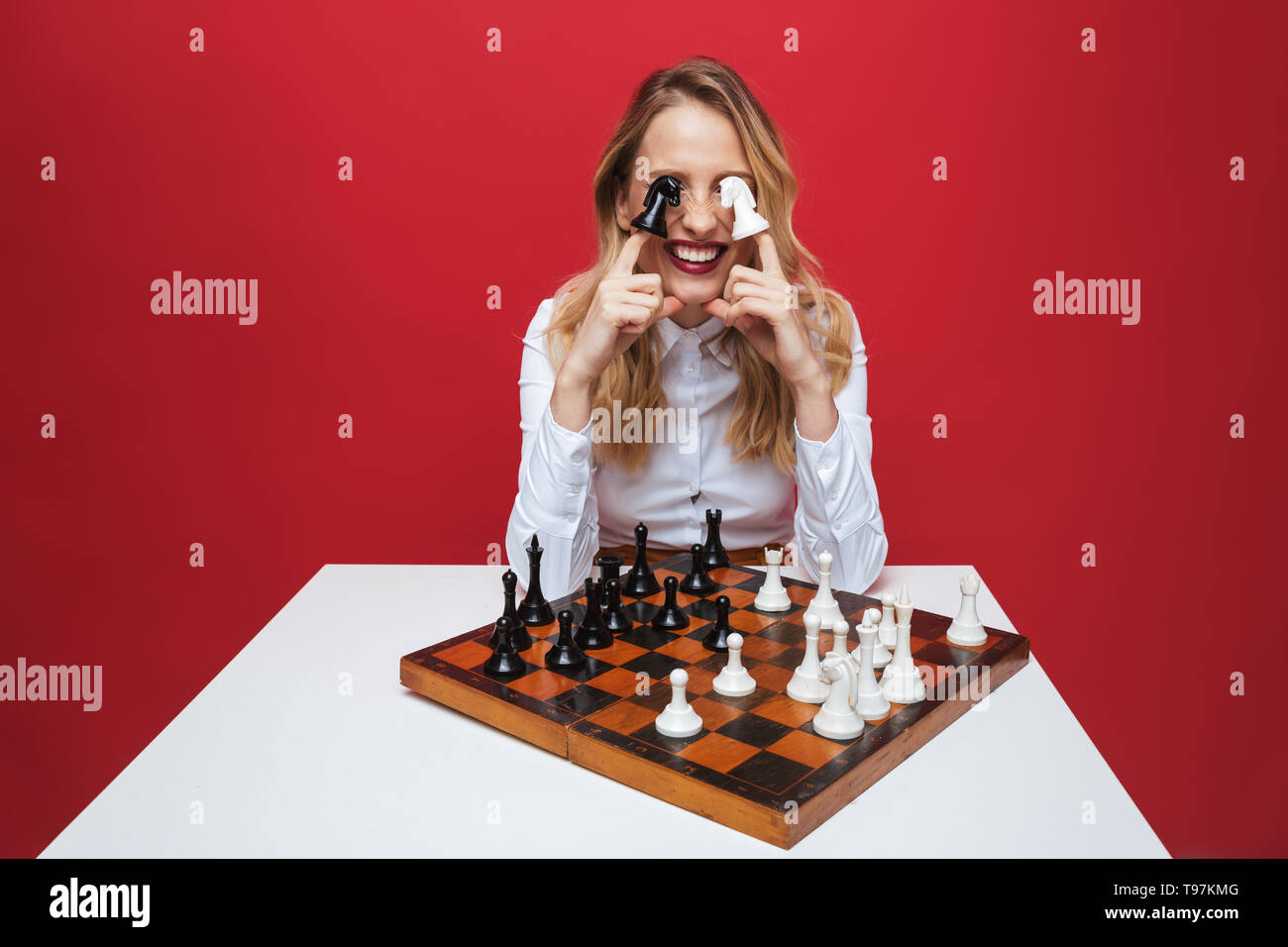 Beautiful young blonde woman wearing white shirt sitting at the table ...