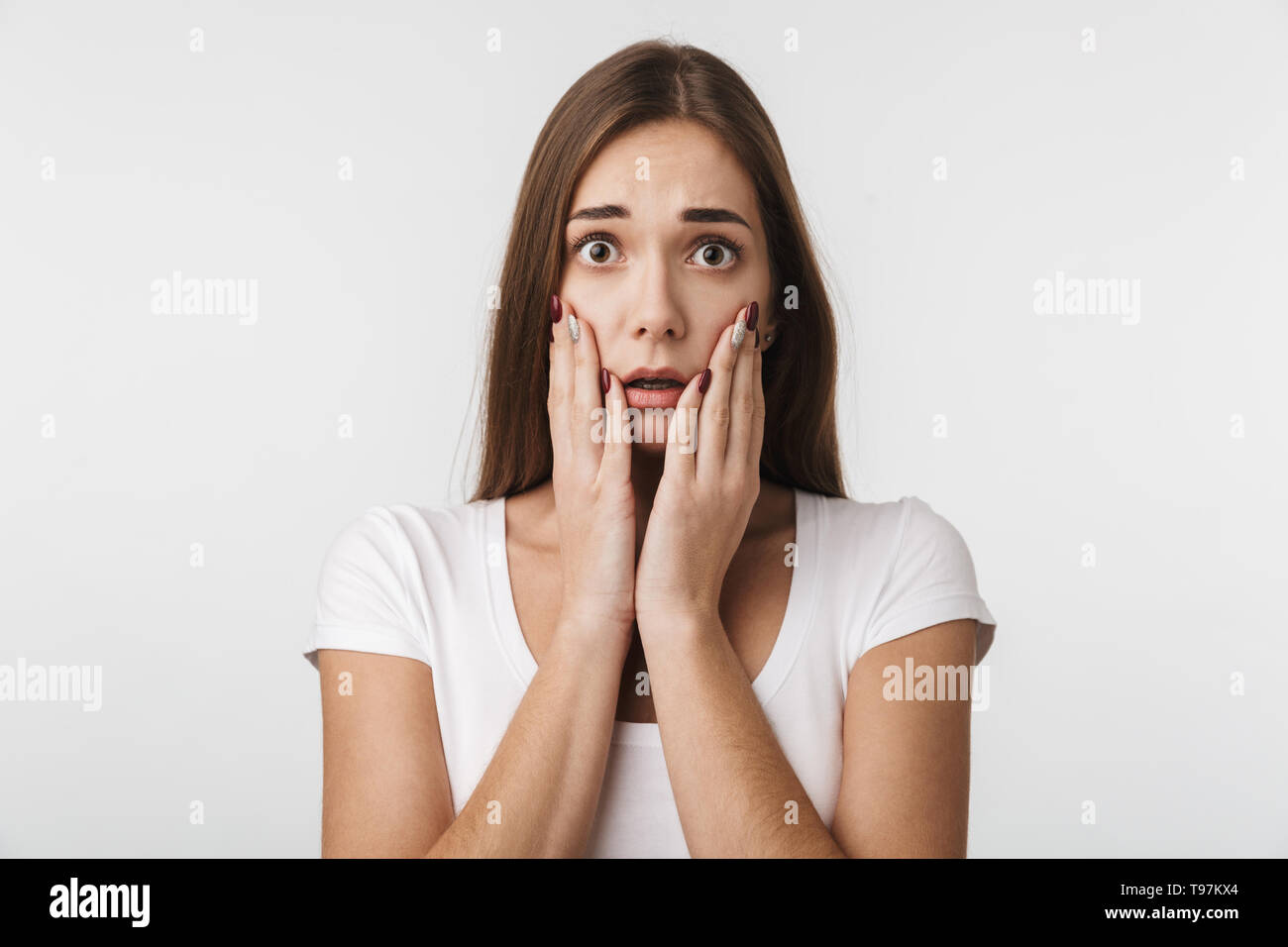 Attractive shocked young woman standing isolated over white background ...